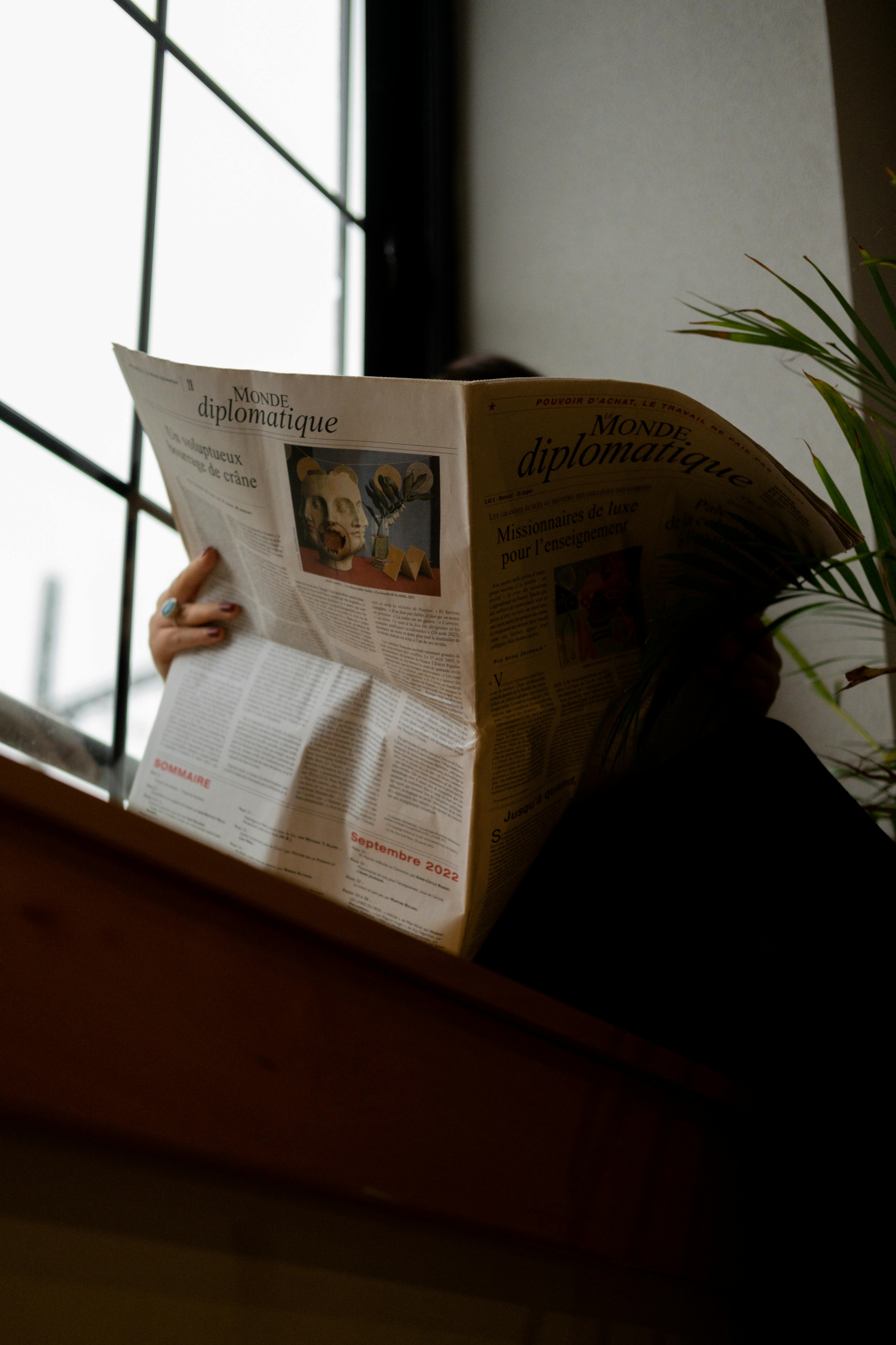 Person in Jacket Holding Magazine in Hand · Free Stock Photo
