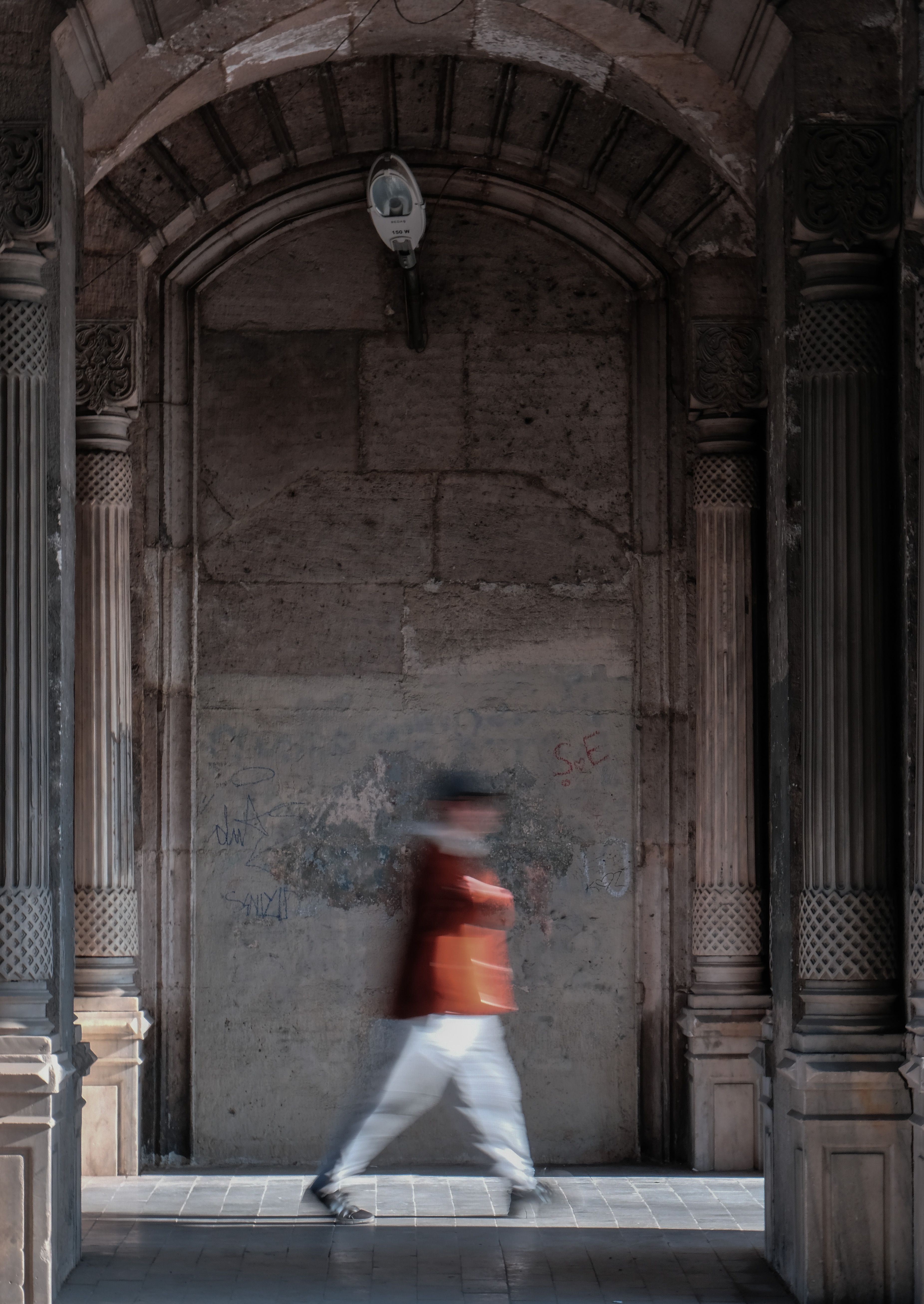 Man Walking under an Arch · Free Stock Photo