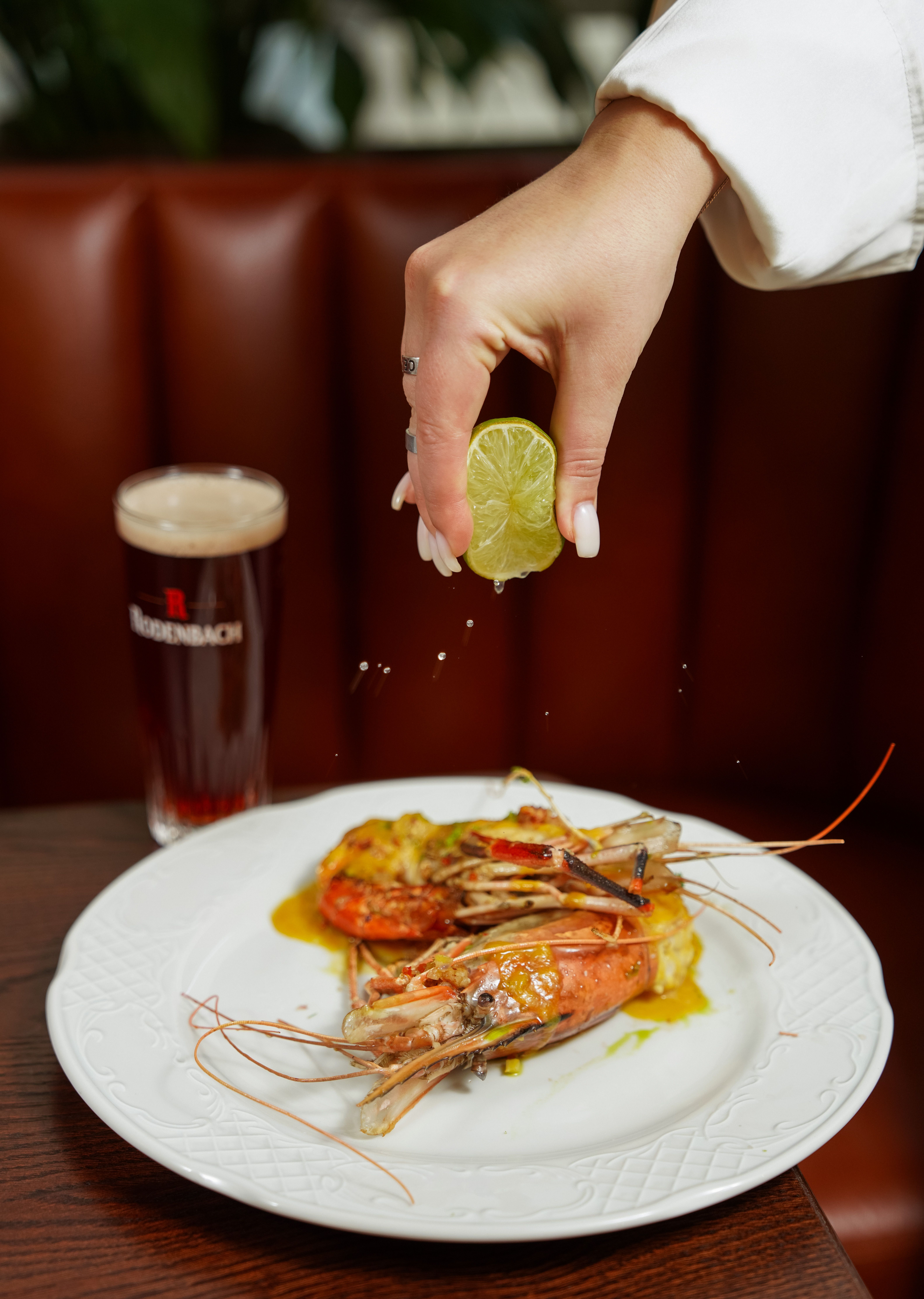 Photo of a Human Hand Squeezing Lime onto Prawns · Free Stock Photo