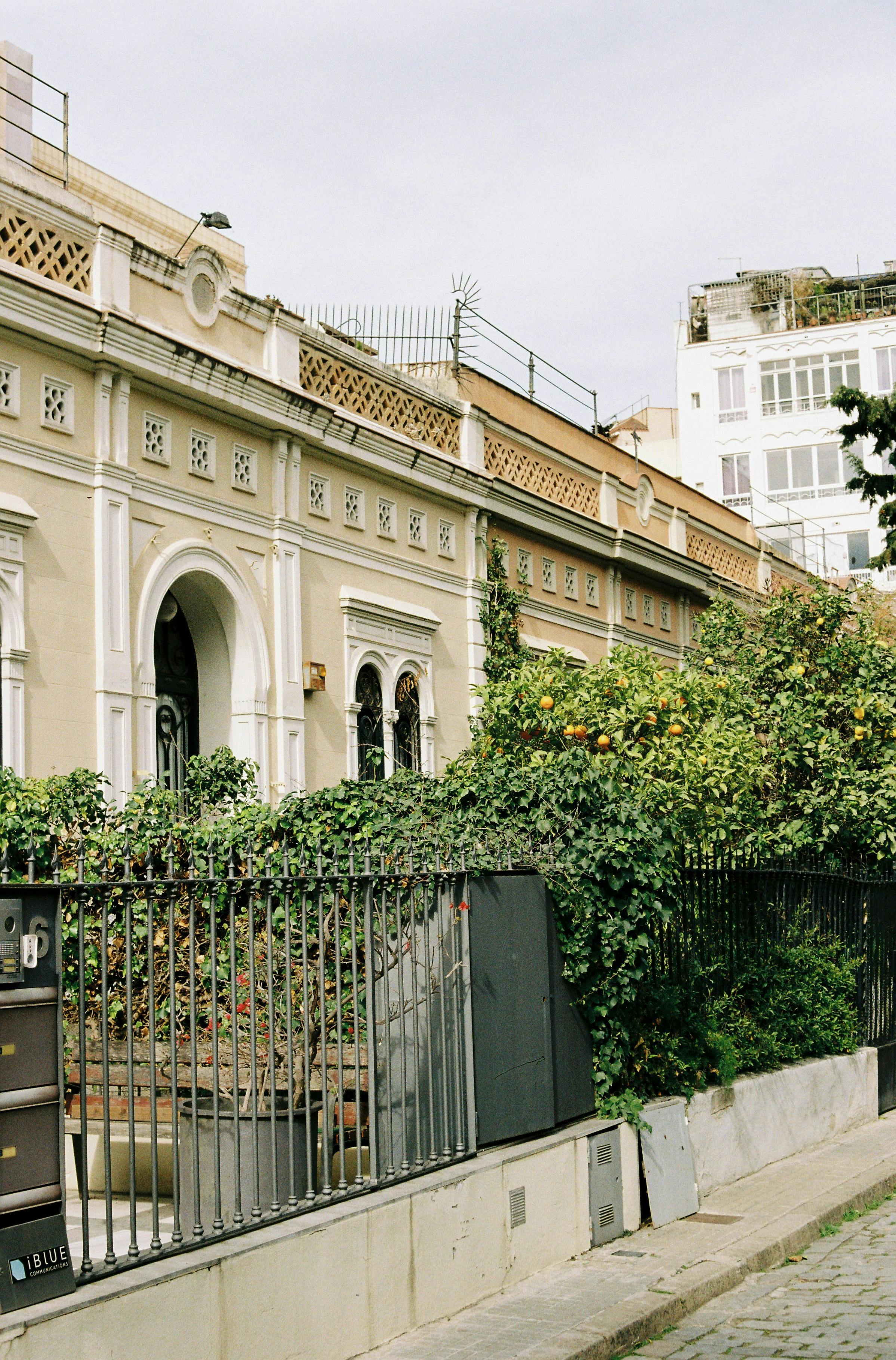 Fence and Bushes near Building · Free Stock Photo