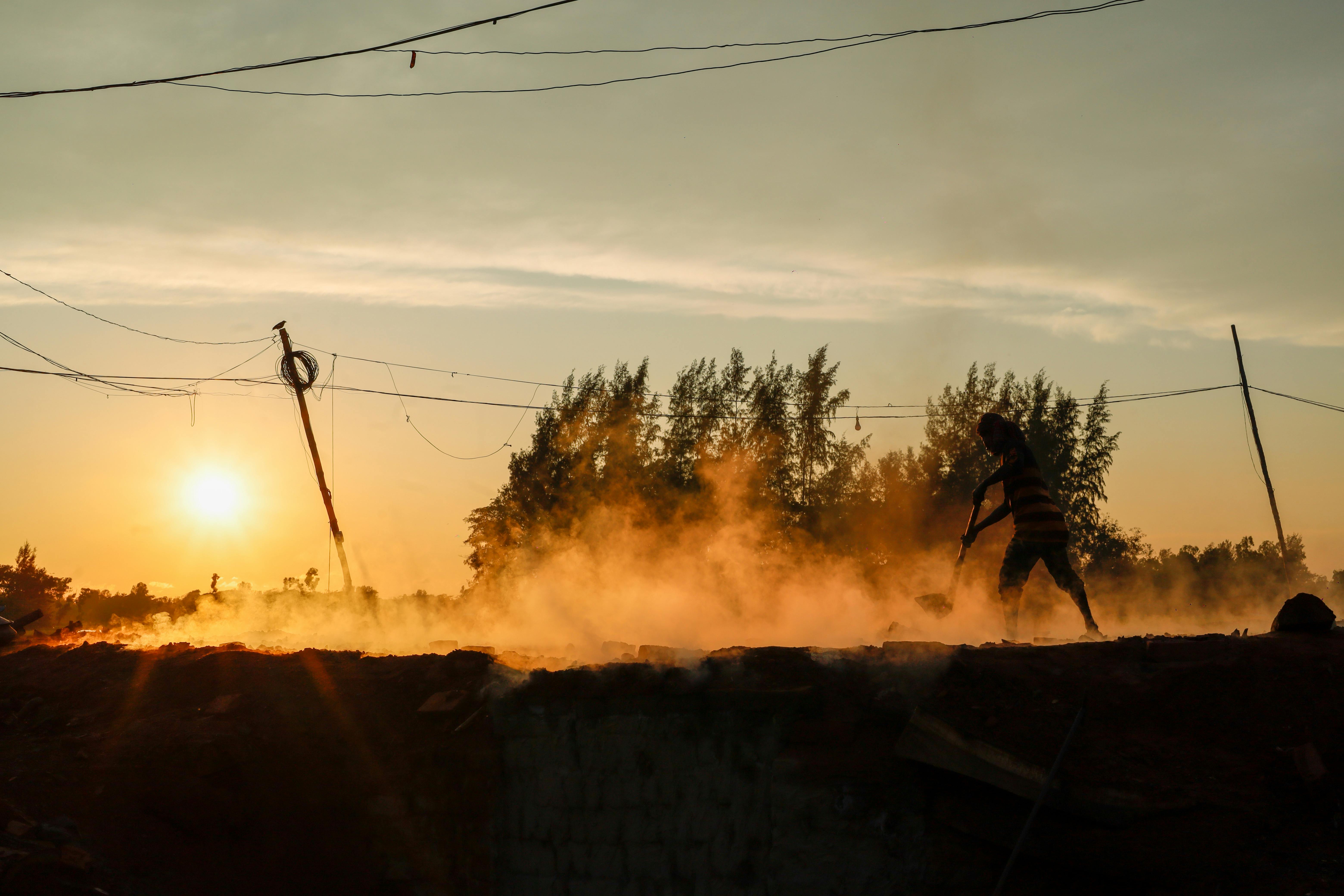 Dust around Man Digging at Sunset · Free Stock Photo