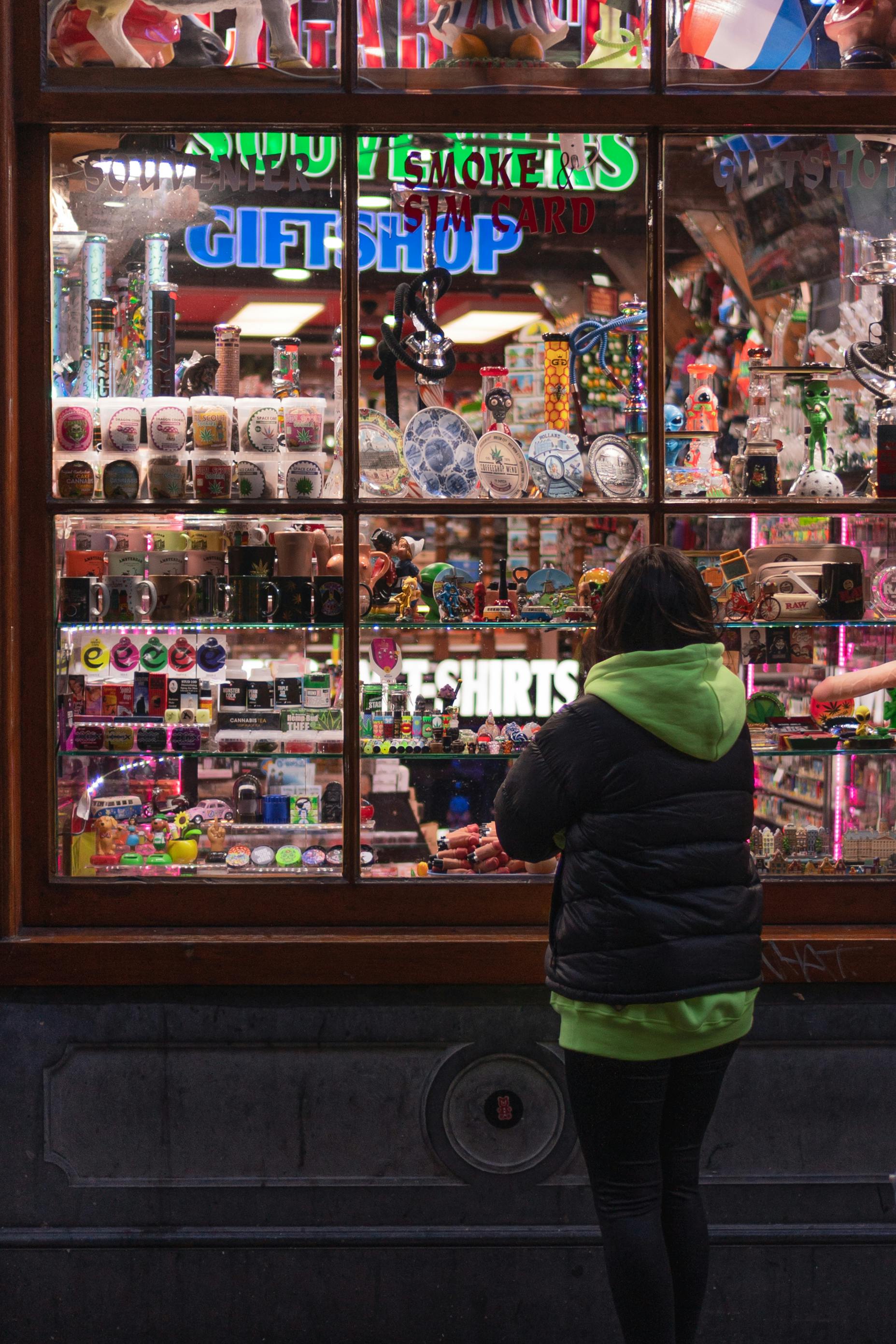 Woman Standing in front of an Illuminated Display in a Window of a Gift ...