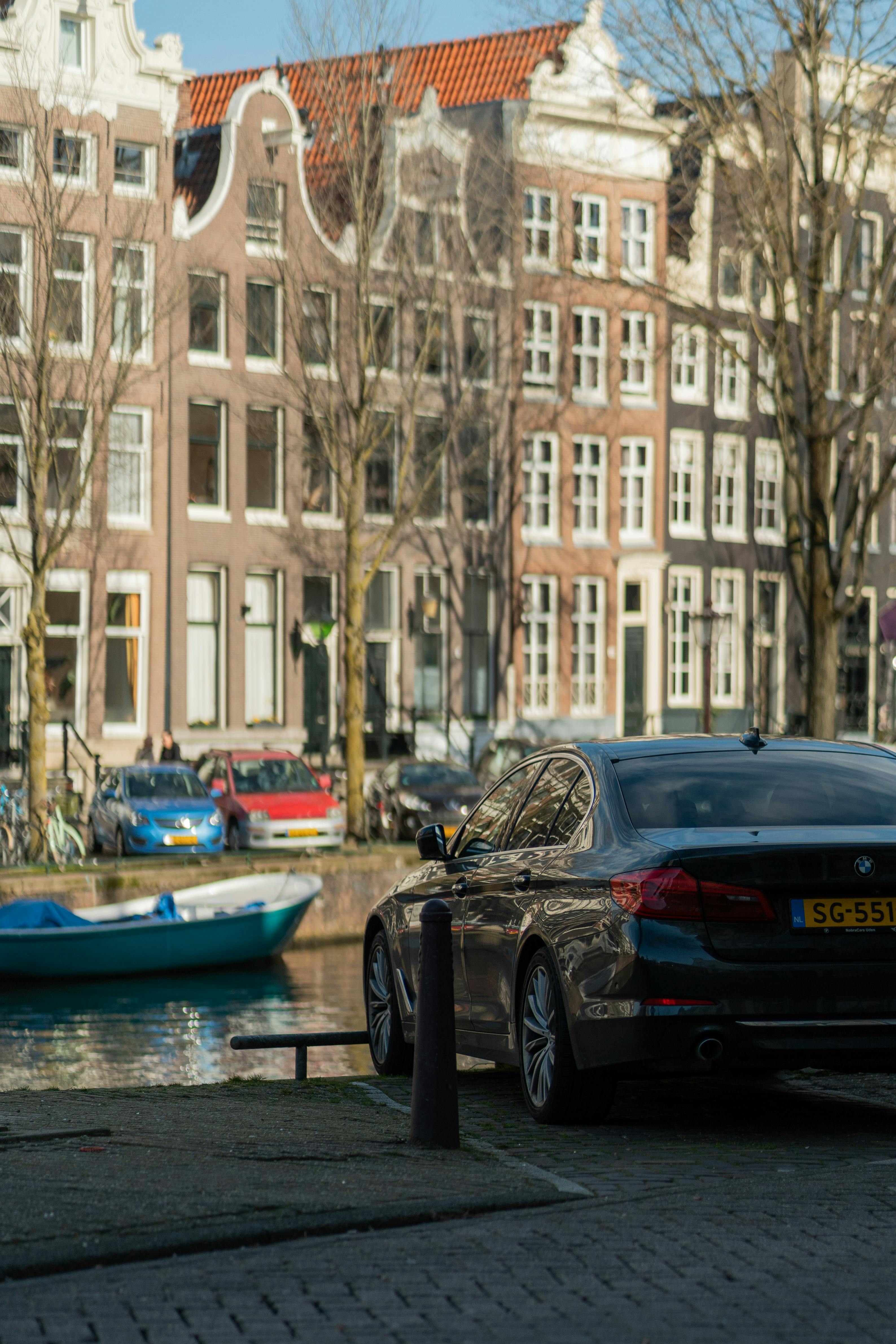 A Car Parked by the Canal in Amsterdam, the Netherlands · Free Stock Photo
