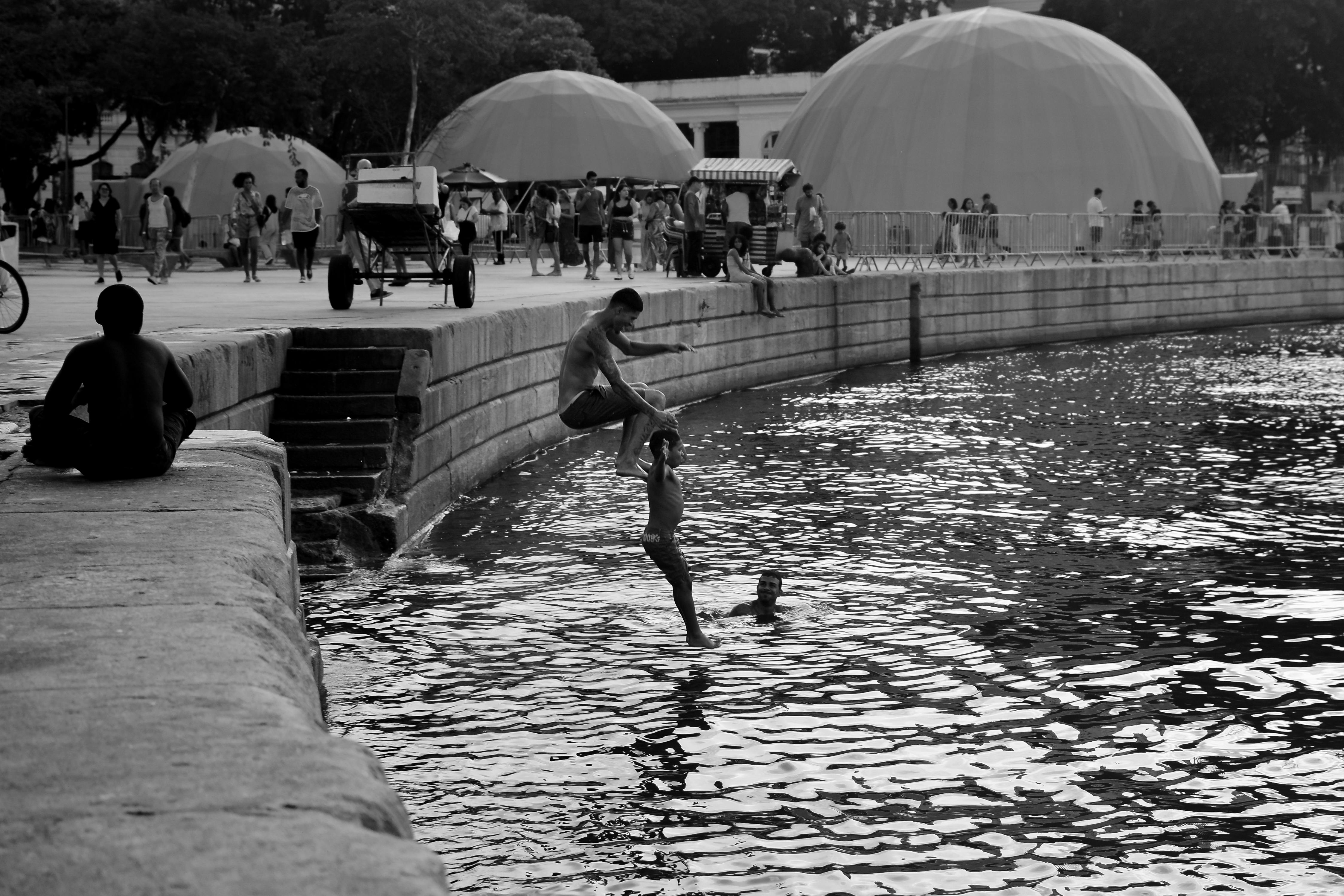 Men Jumping into Water from Promenade · Free Stock Photo