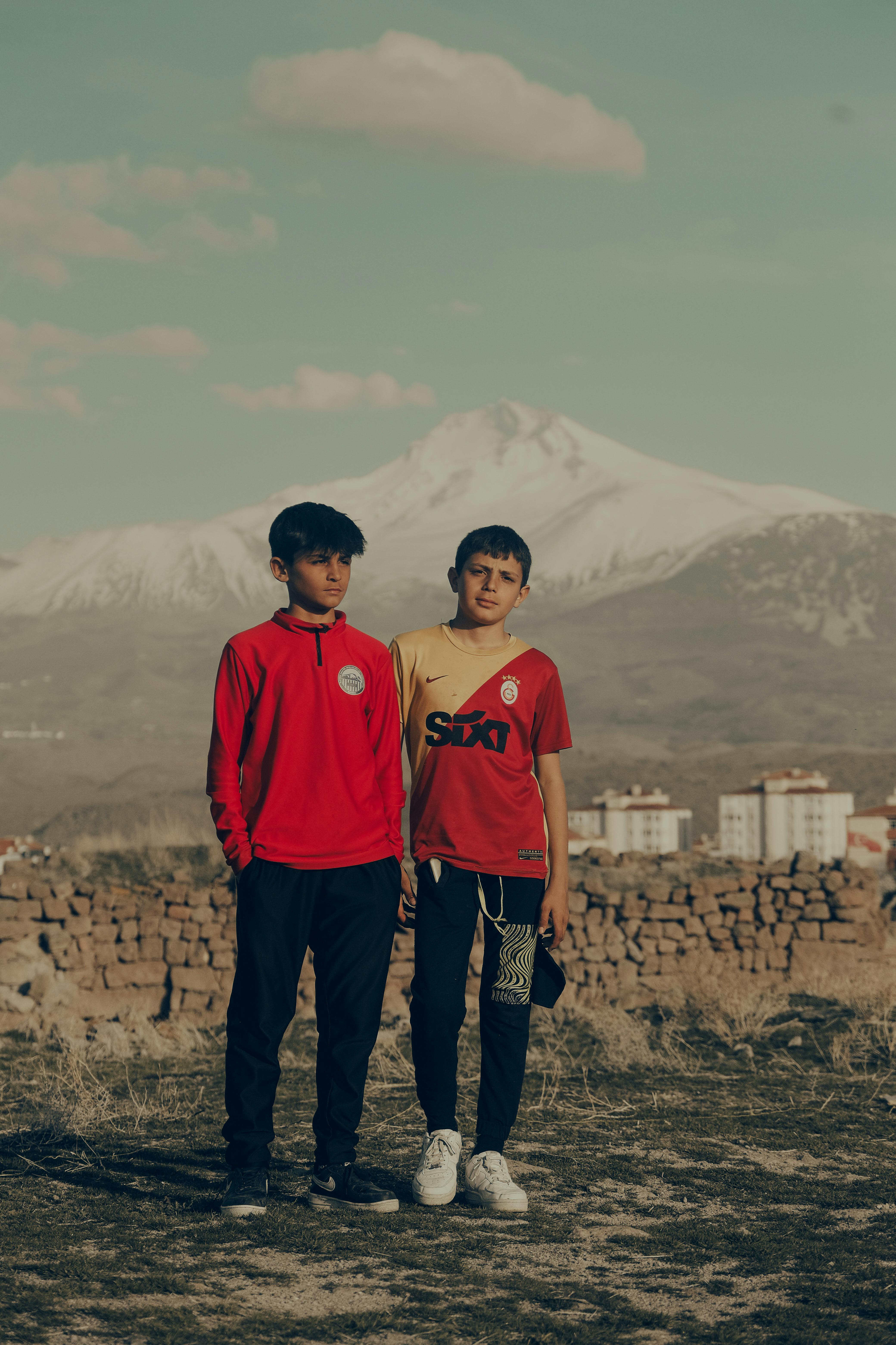Two Boys Standing on a Meadow on the Background of a Mountain · Free ...