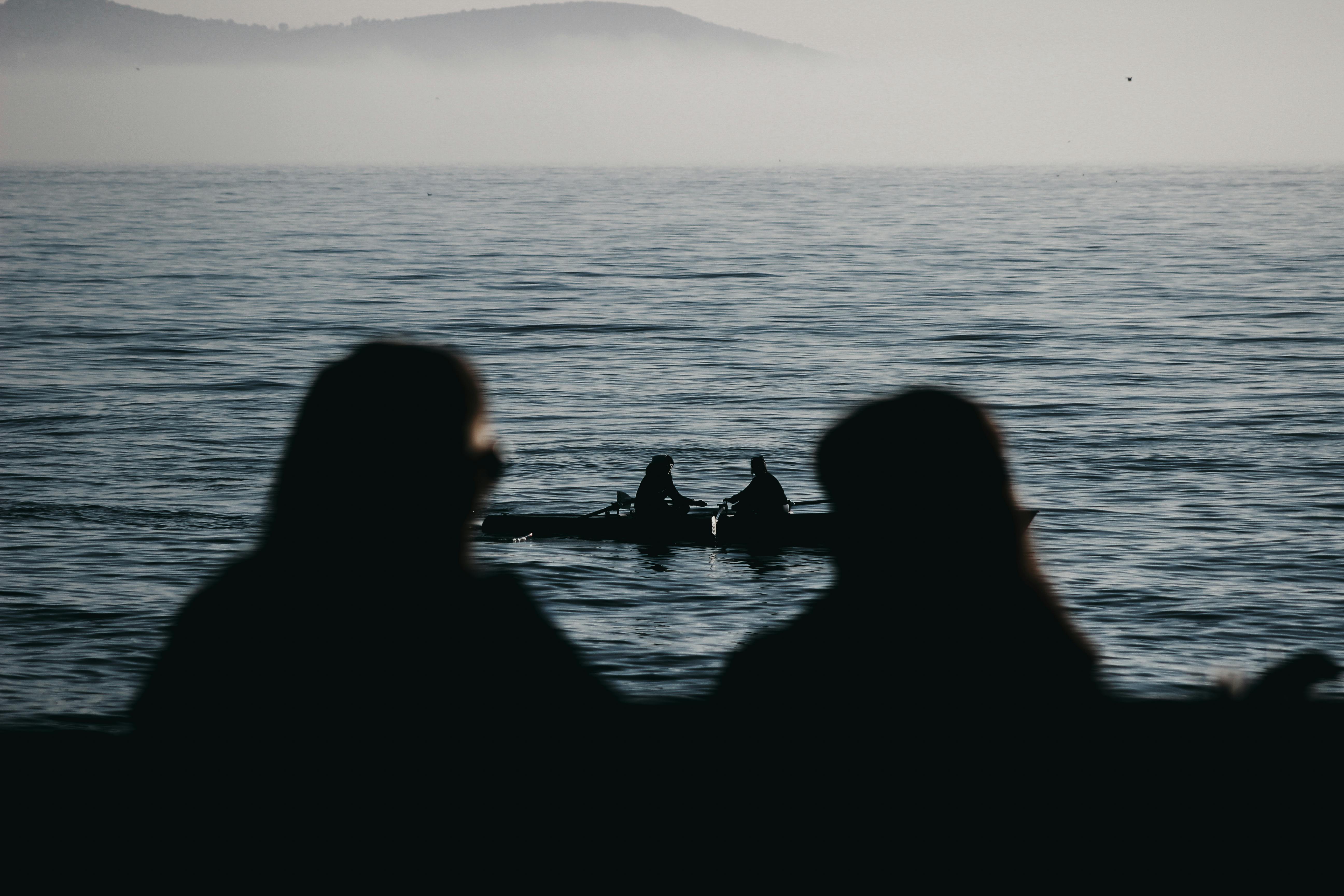 Two Person Riding Boat on Body of Water · Free Stock Photo