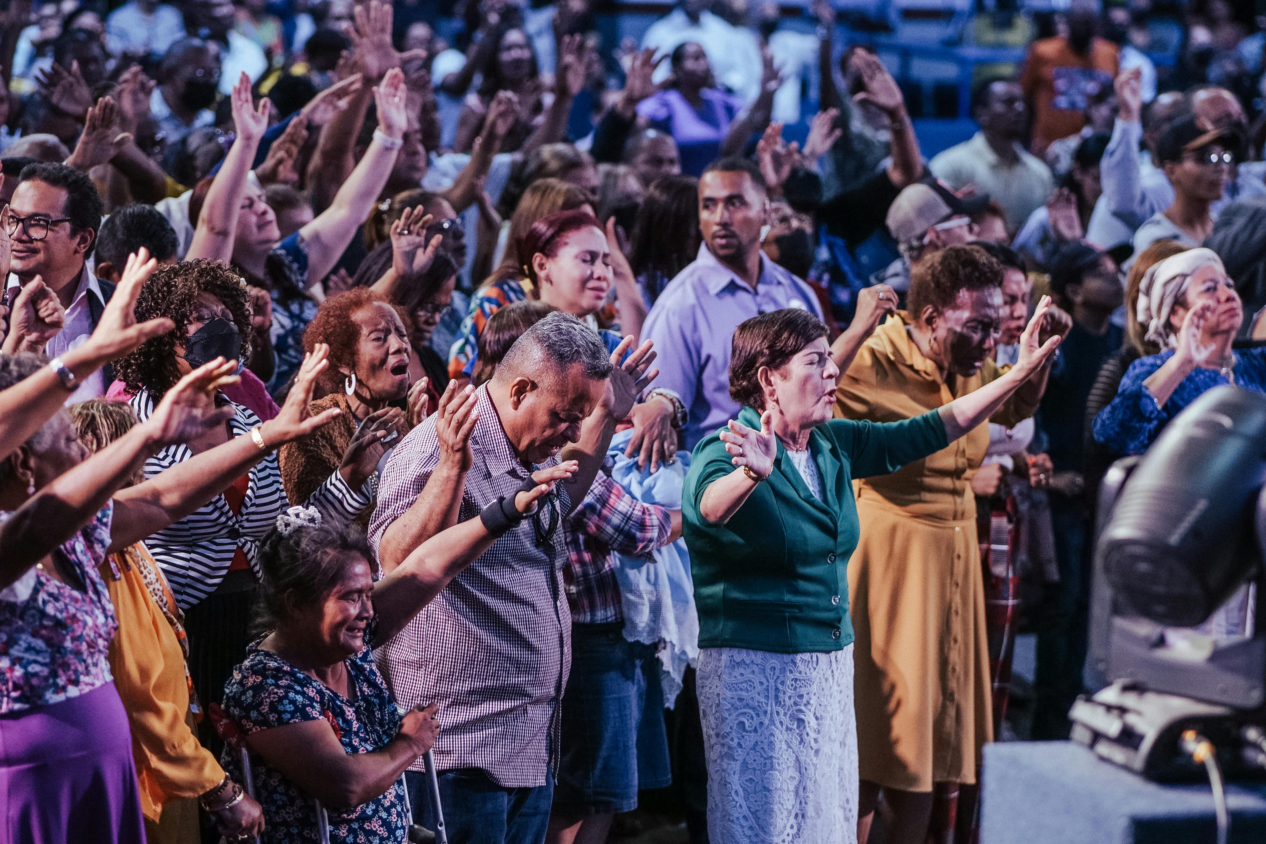 A group of people in a church with their hands raised · Free Stock Photo