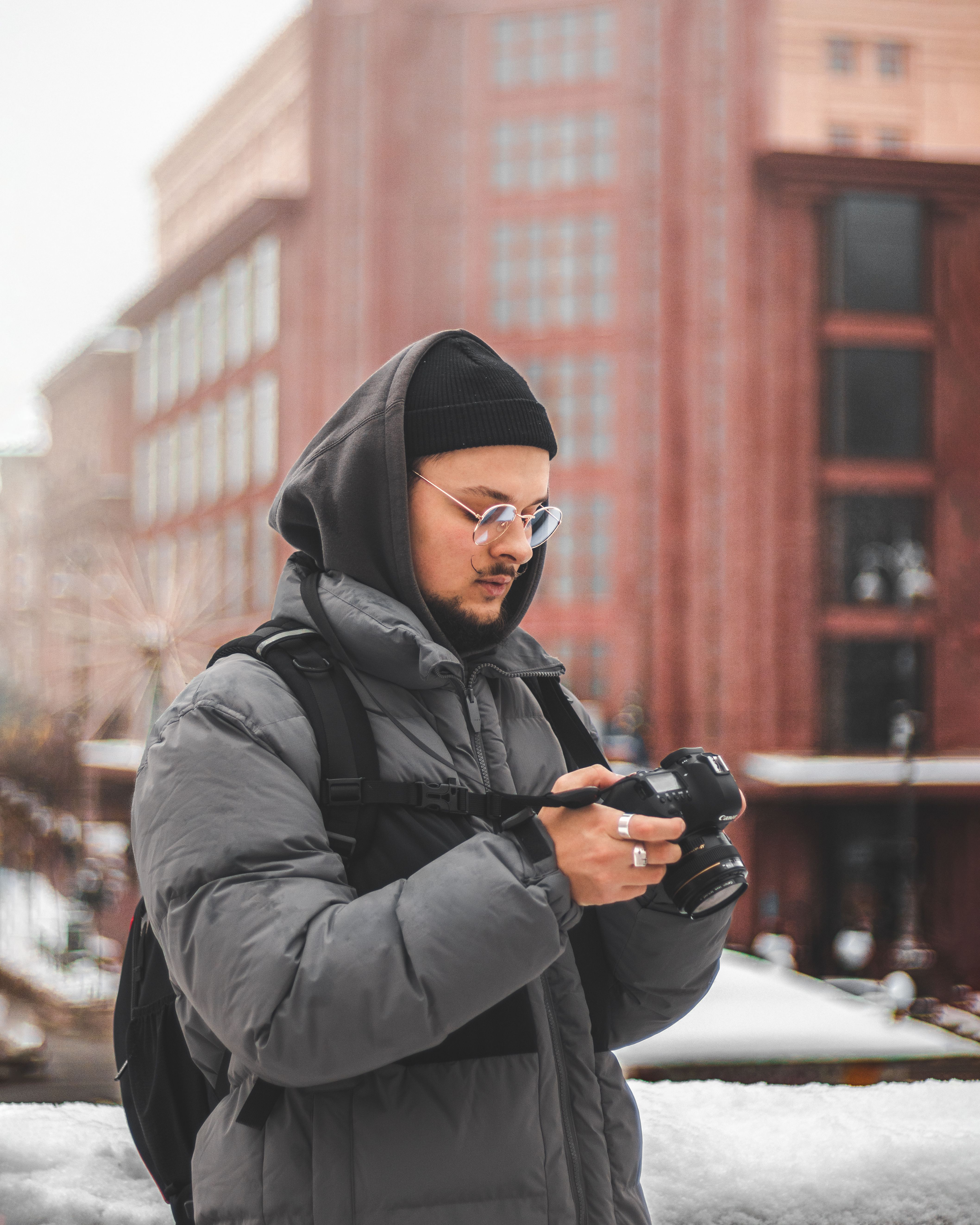 Photographer in Gray Jacket Looking at Camera Screen · Free Stock Photo