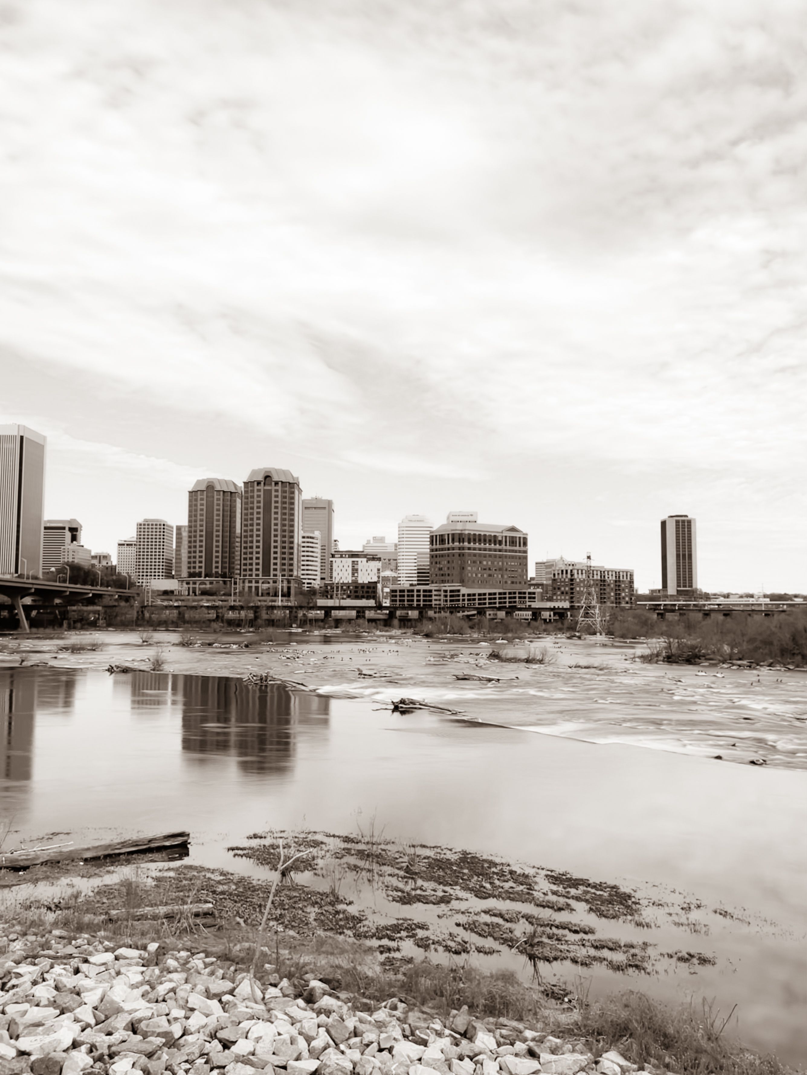 A sepia photo of a city skyline with a river · Free Stock Photo
