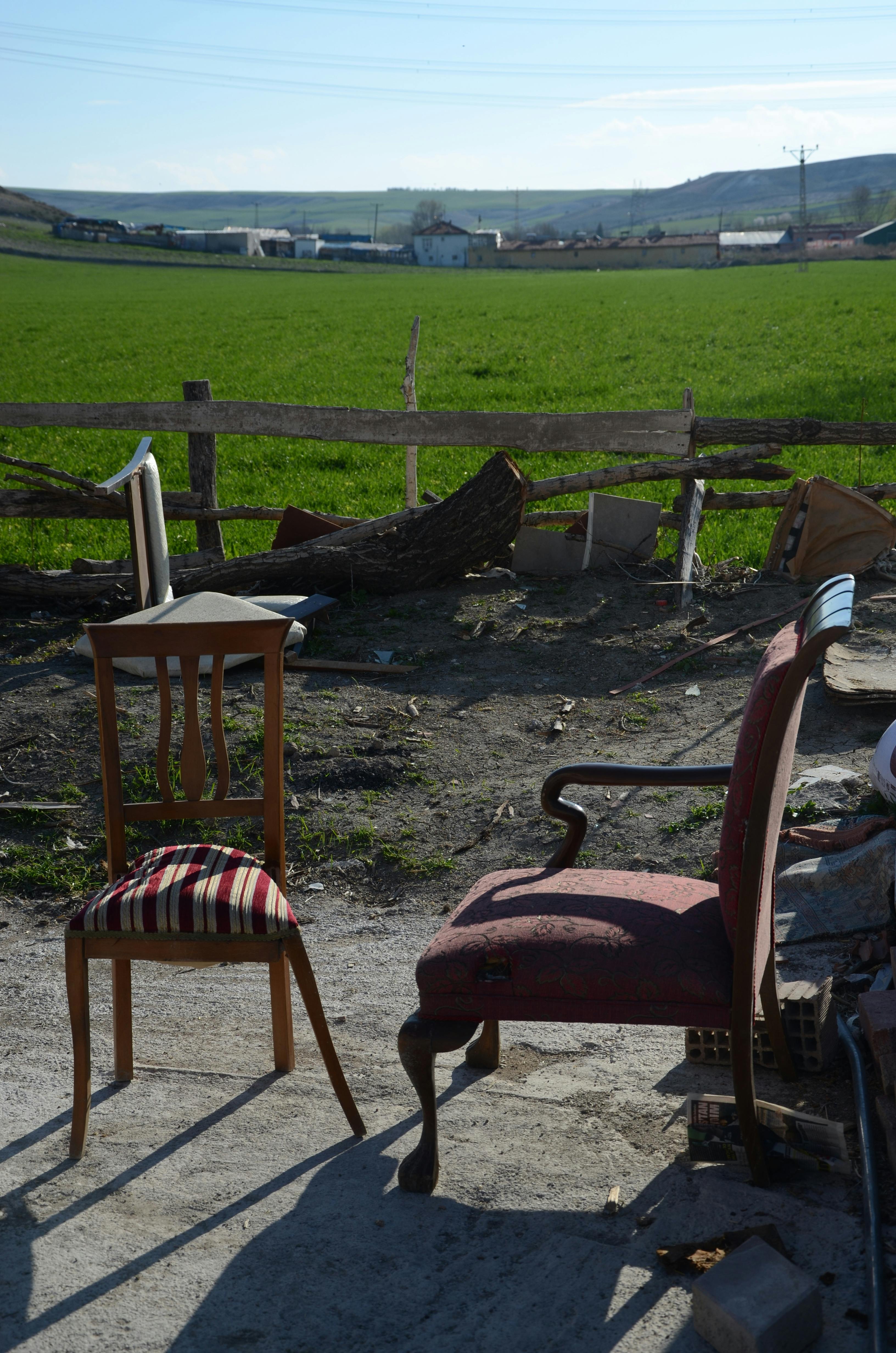 Empty Chairs Standing in Front of a Fenced Field · Free Stock Photo