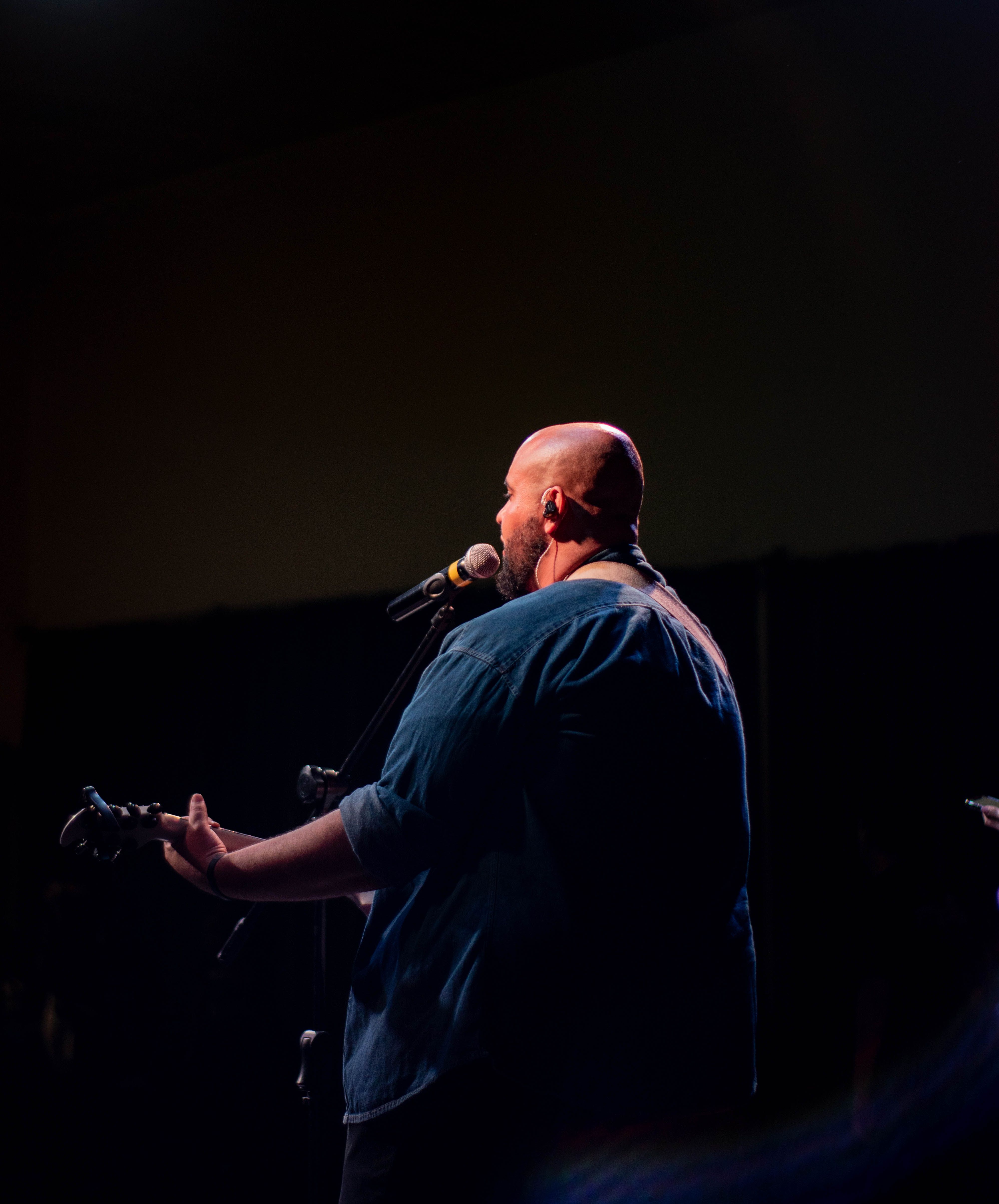Singer Playing Guitar on Stage · Free Stock Photo
