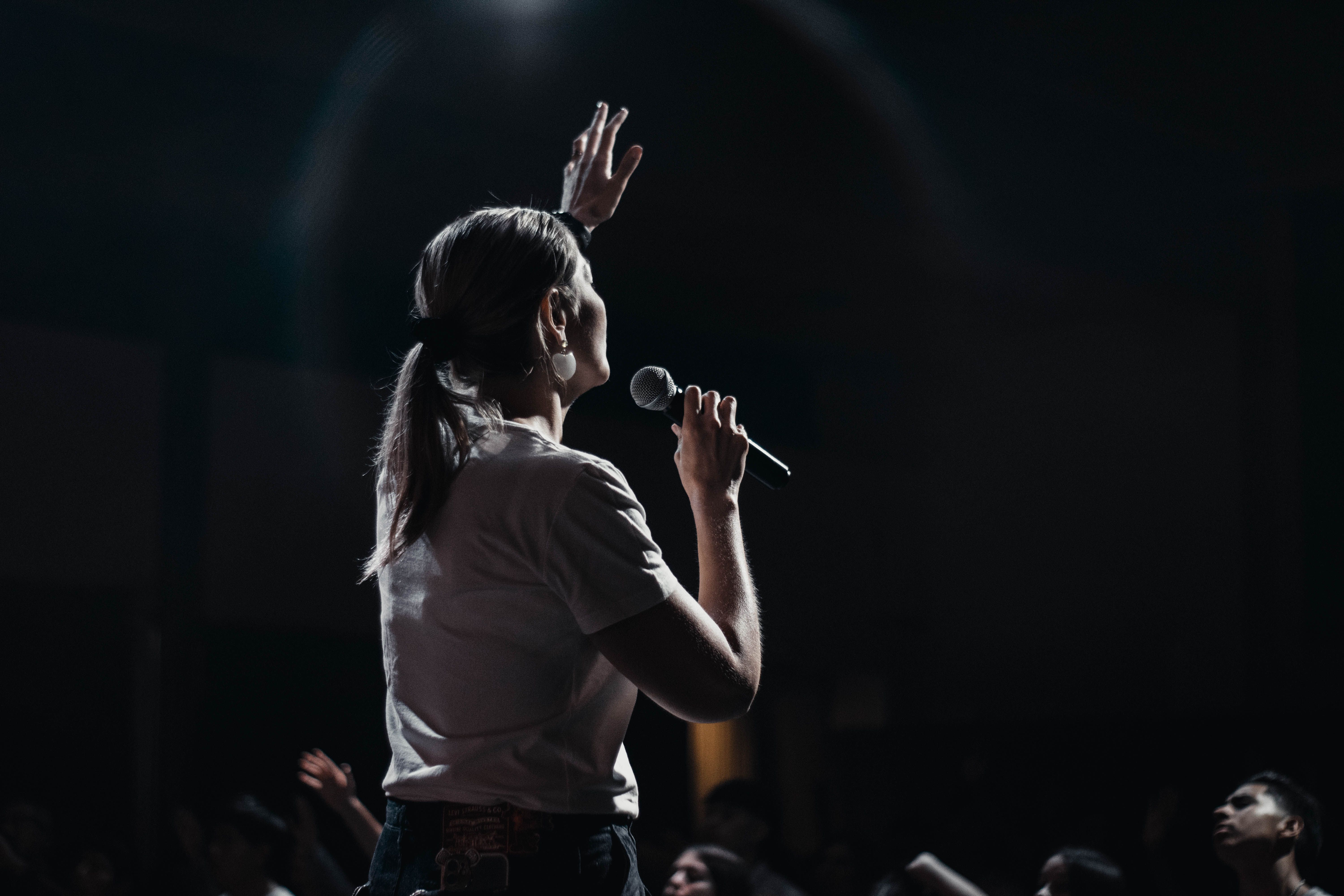 Singer Performing at a Concert with Her Hand Raised · Free Stock Photo