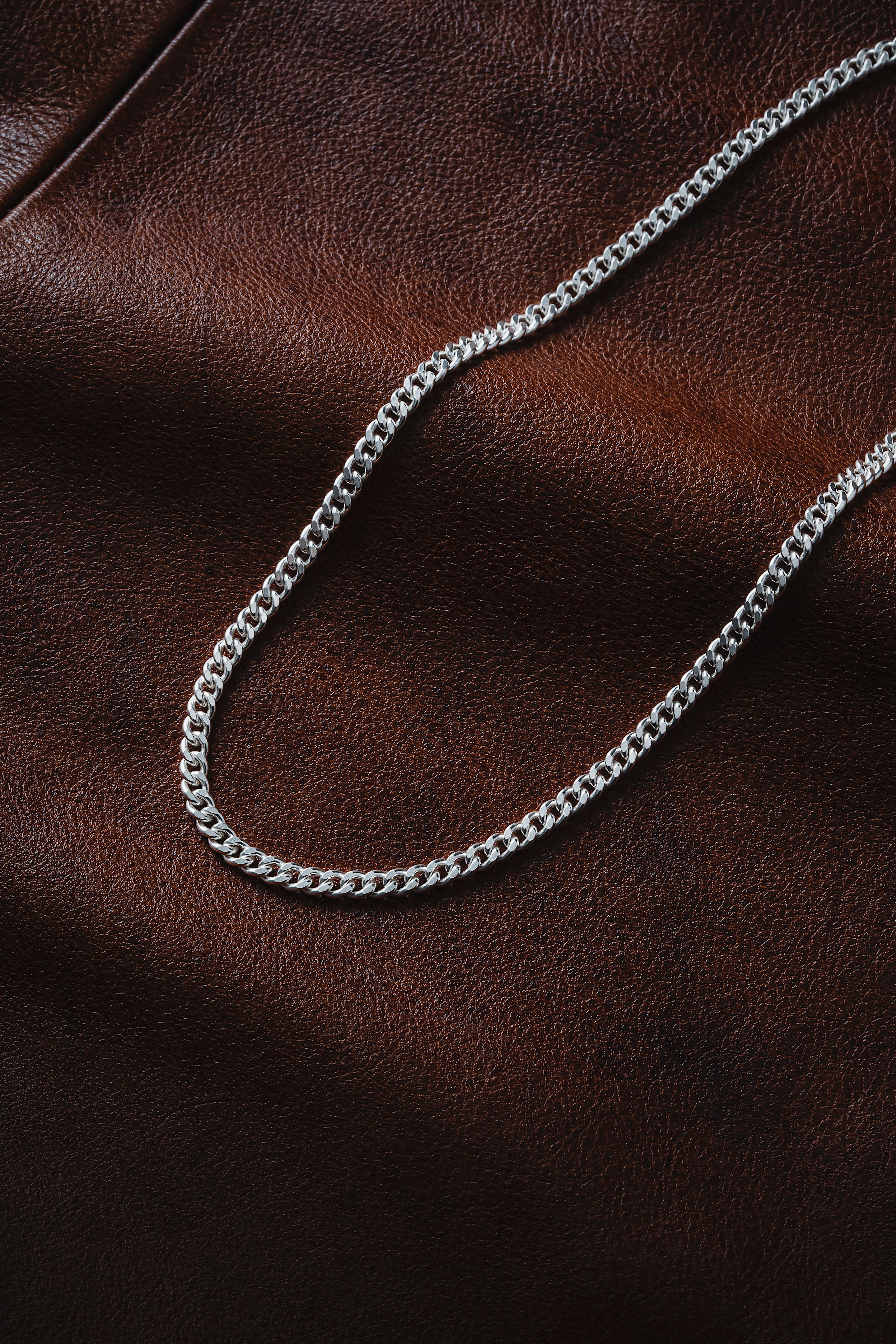 Silver Chain on Leather Texture · Free Stock Photo