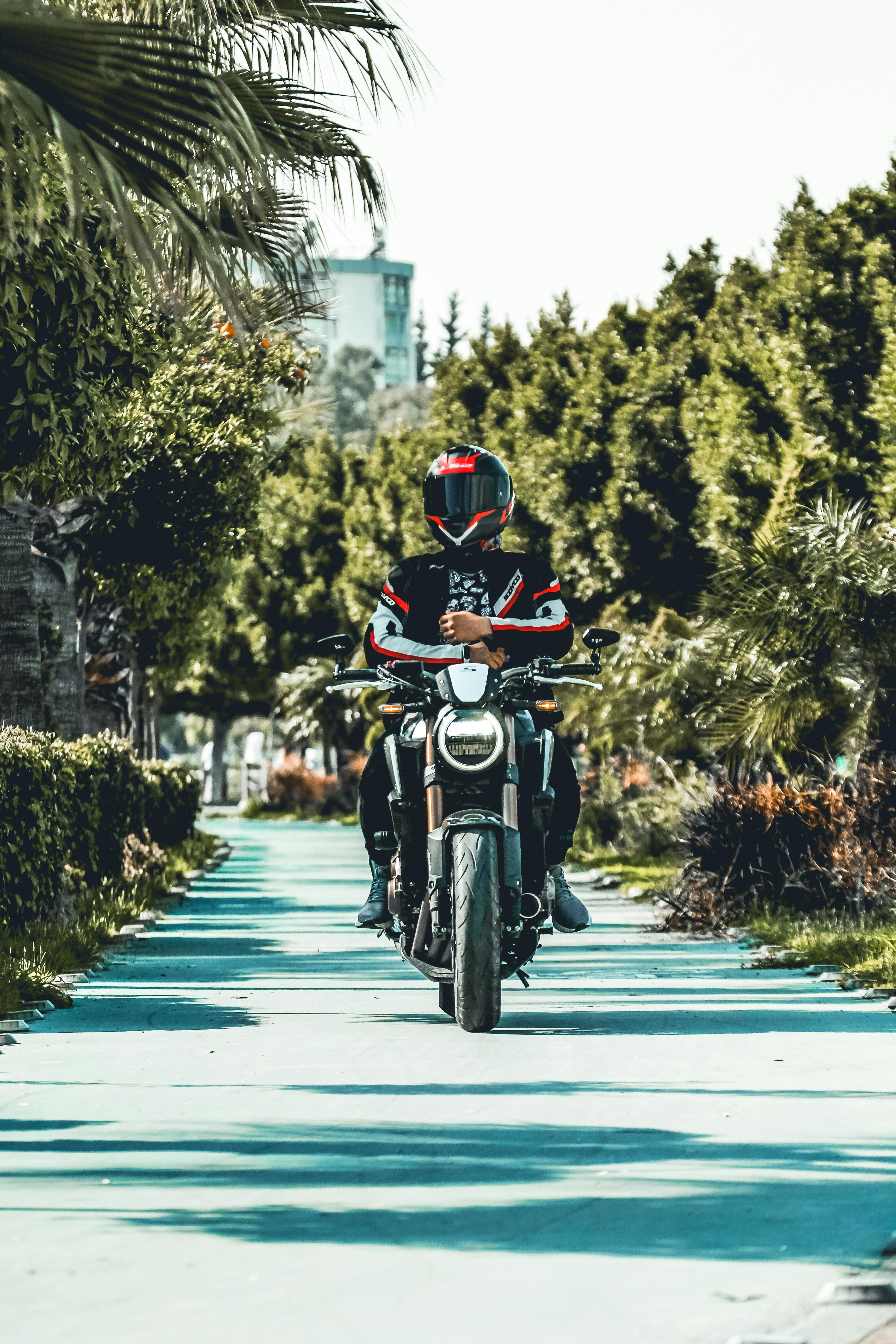 Man Driving a Motorcycle Along an Alley · Free Stock Photo
