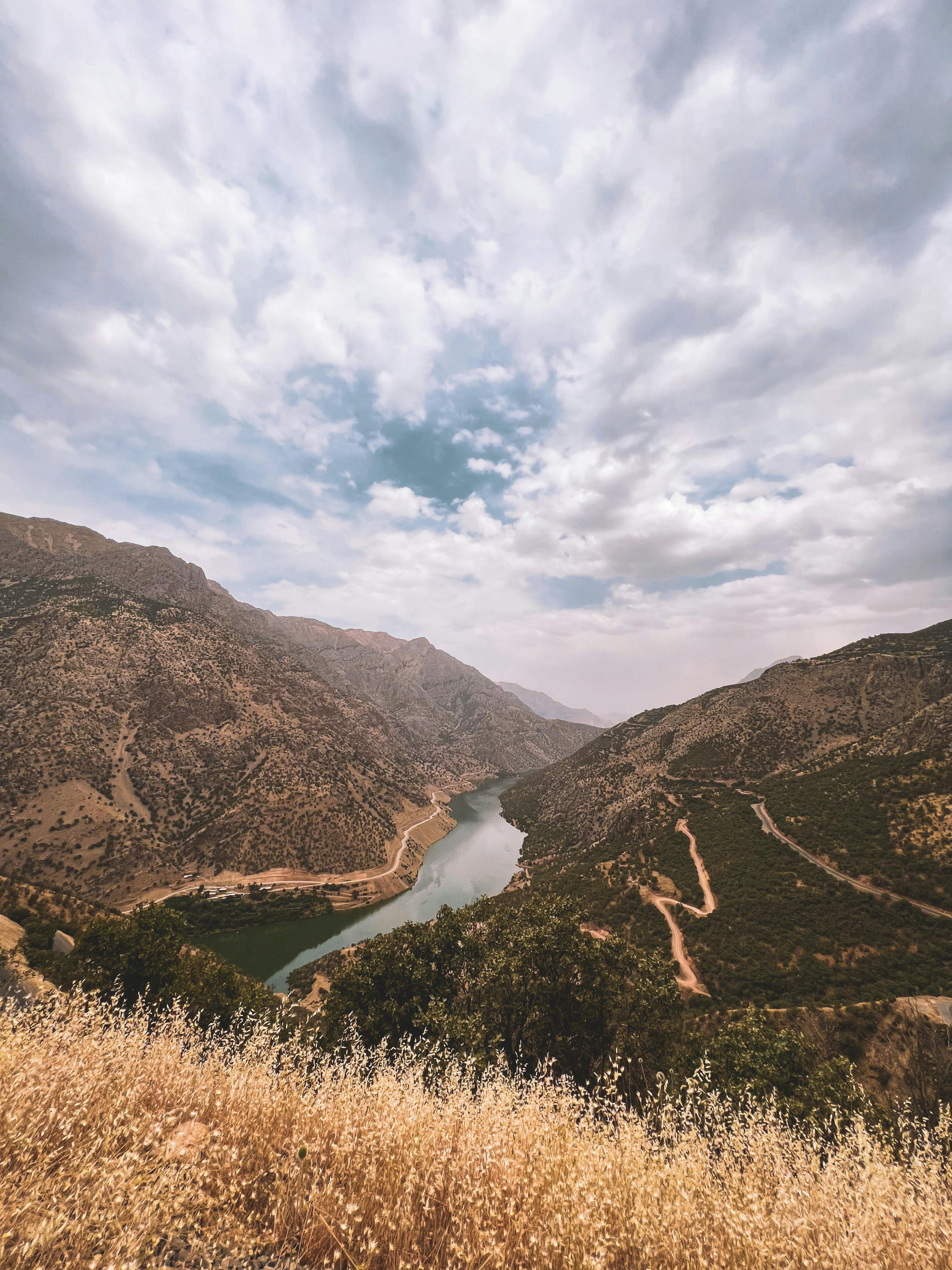 River between Mountains under Cloudy Sky · Free Stock Photo