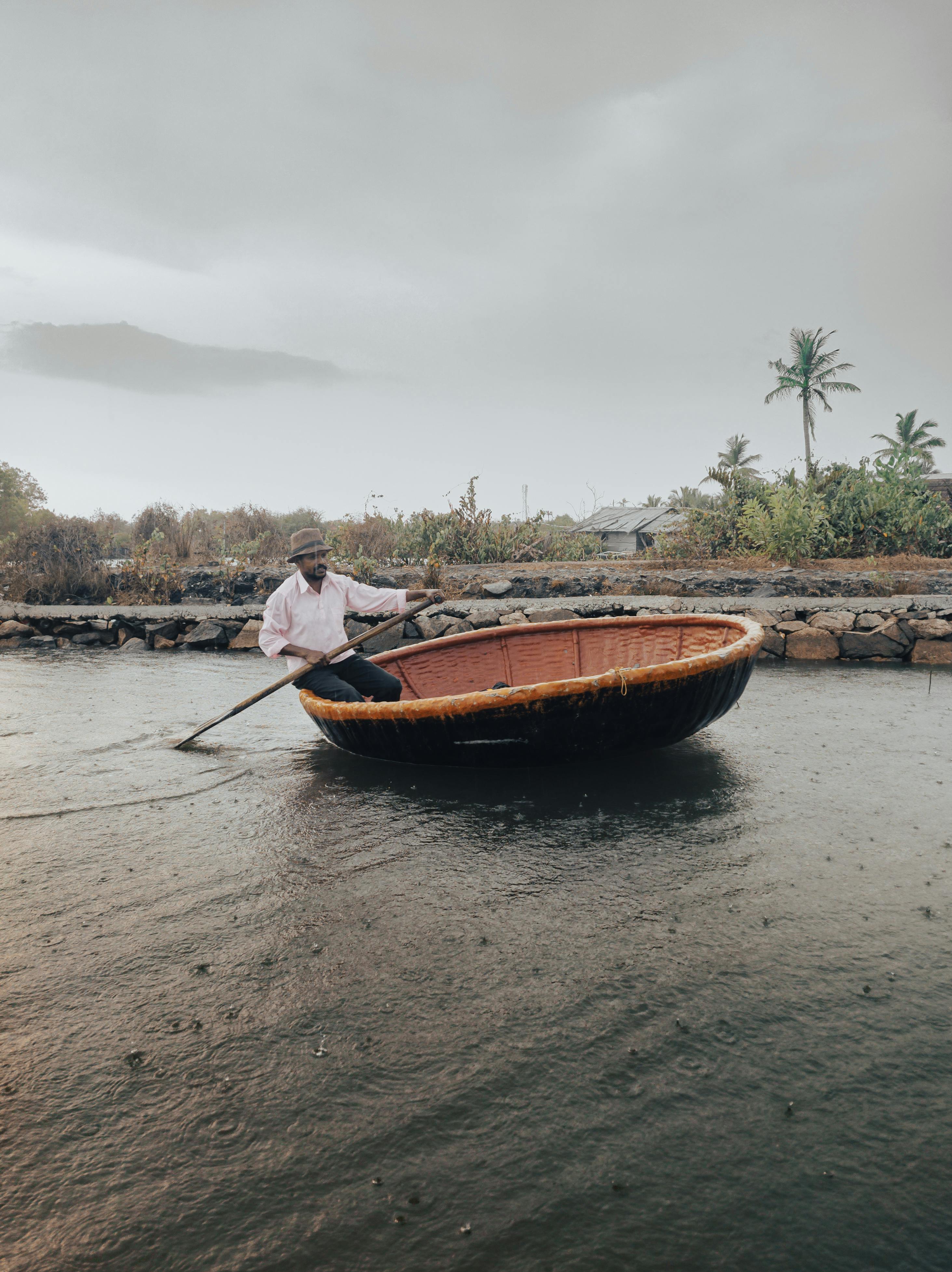 Man Sailing in Rowboat near Seashore · Free Stock Photo
