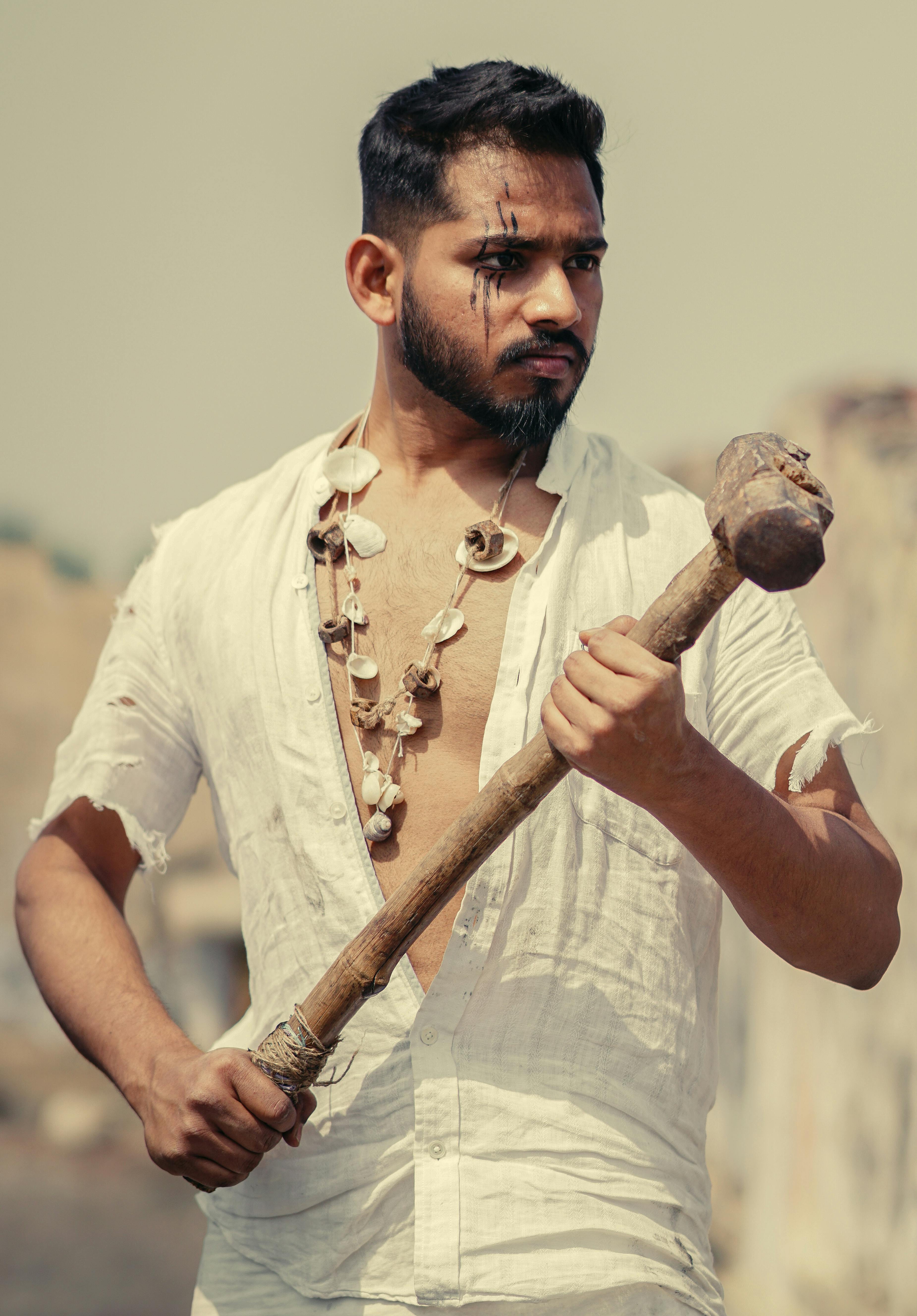 Man Wearing Seashell Necklace Holding Mallet · Free Stock Photo