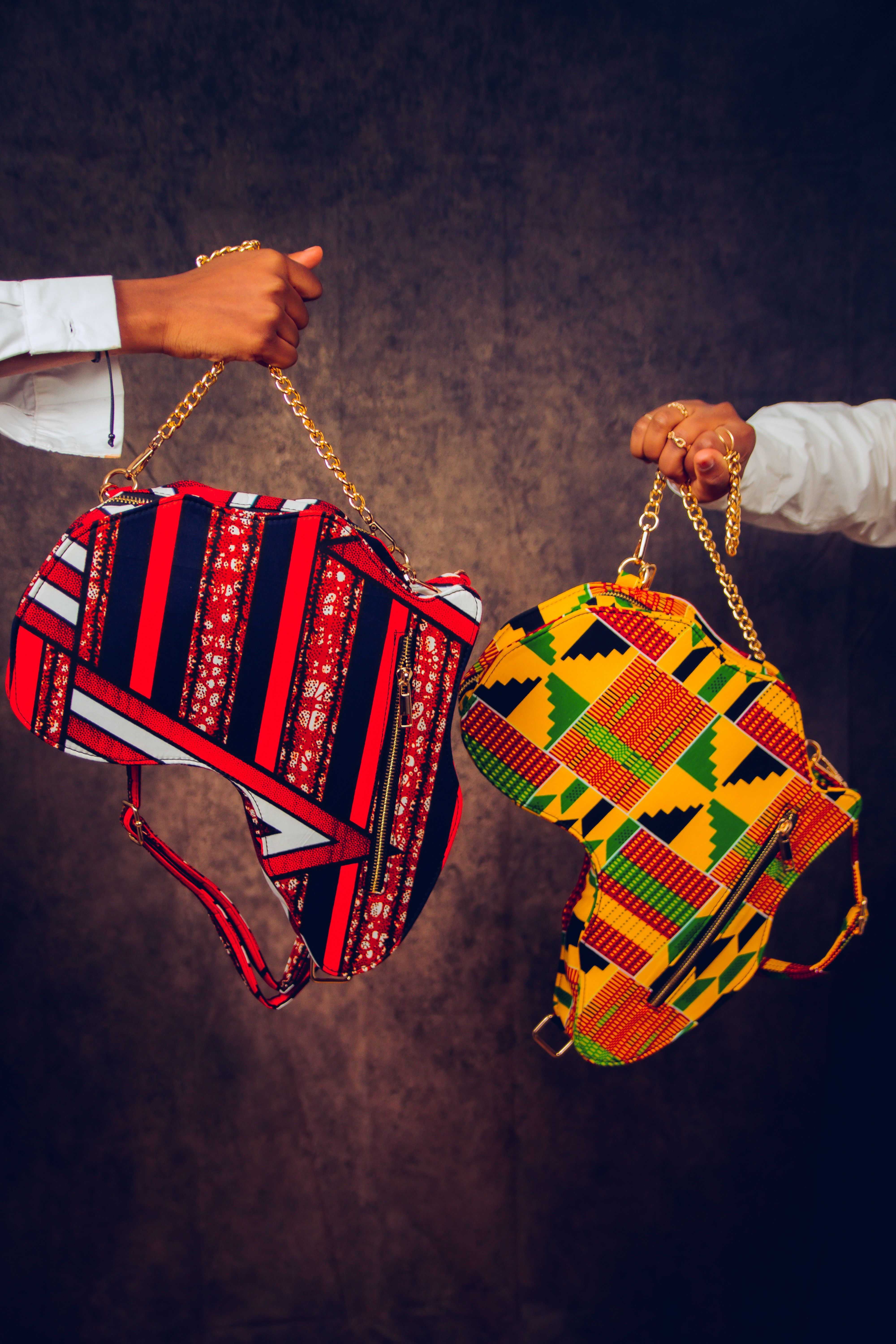 Hands Presenting Handbags in Shape of Africa Decorated with Traditional ...