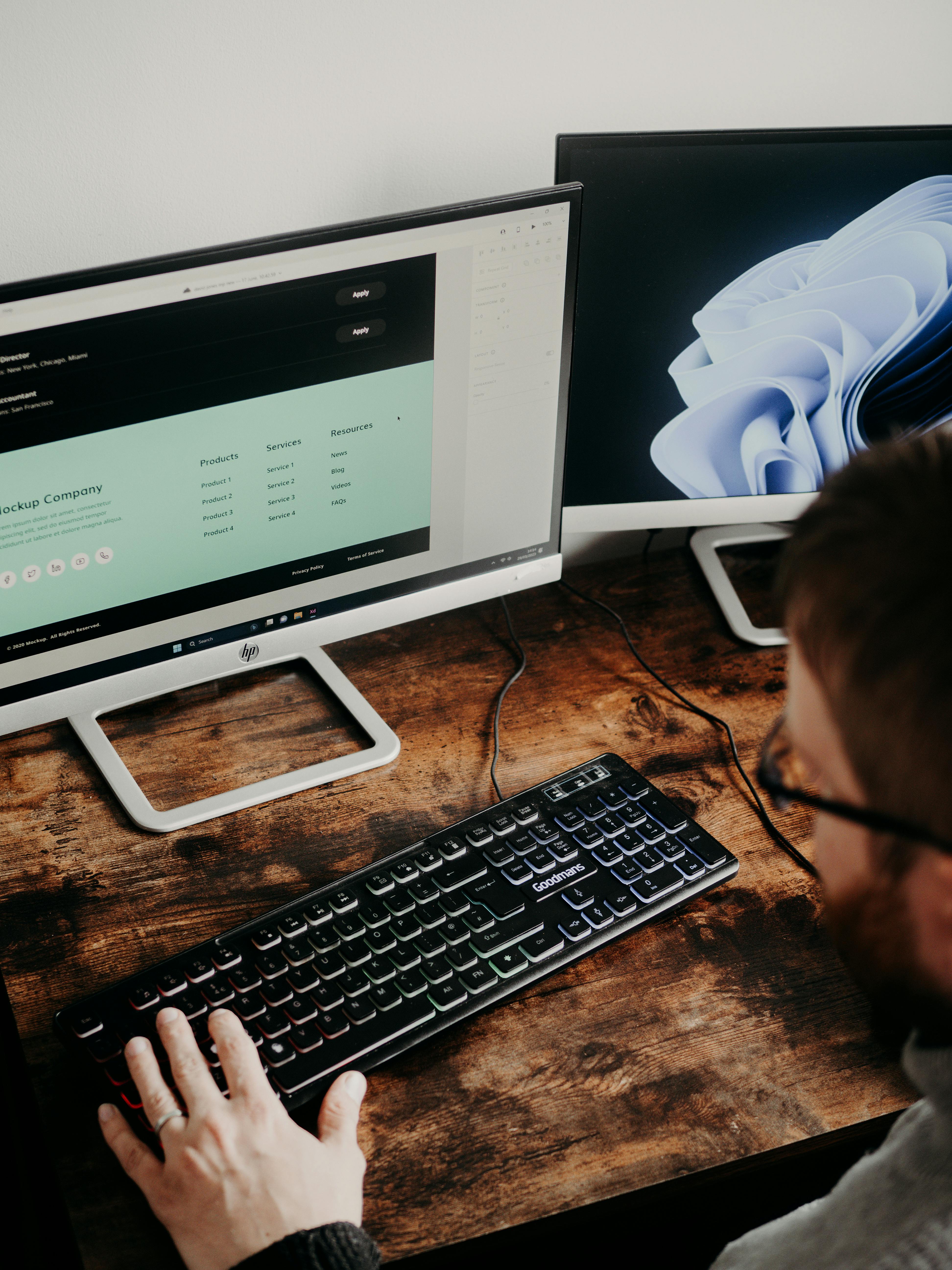 Man Coding on Computers Sitting at Desk · Free Stock Photo