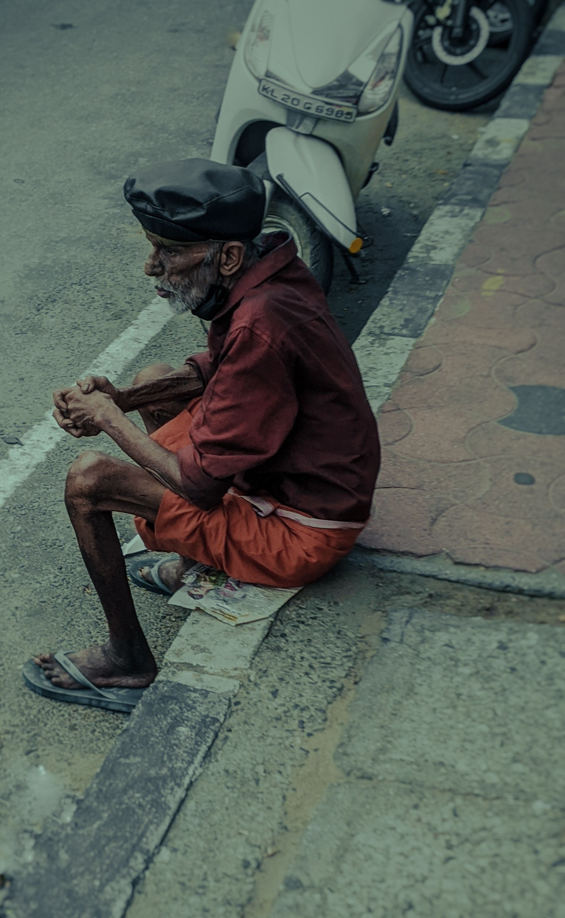 Man Sitting on Curb on Street · Free Stock Photo