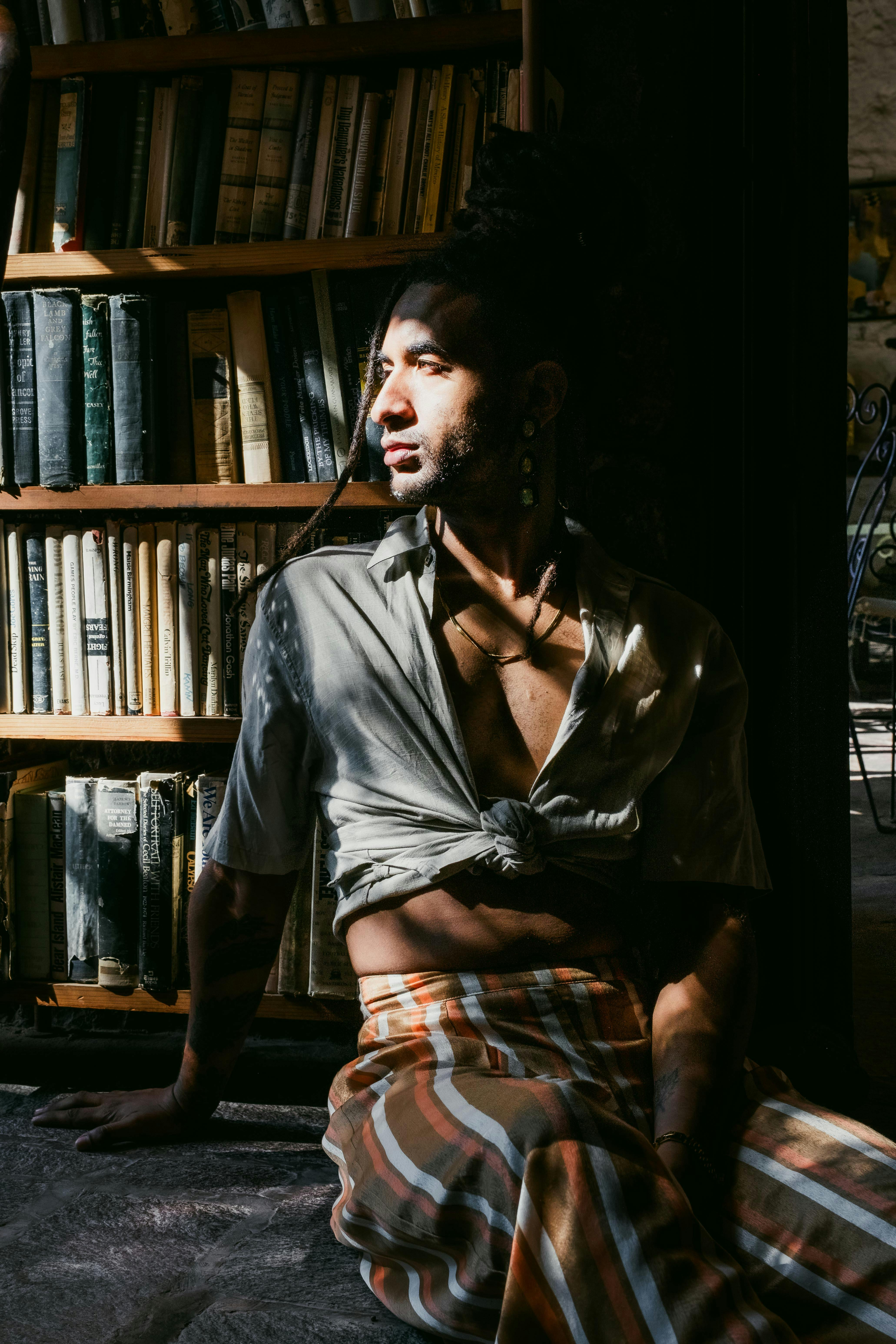 Young Man with Dreadlocks Sitting on the Floor and Leaning against a ...