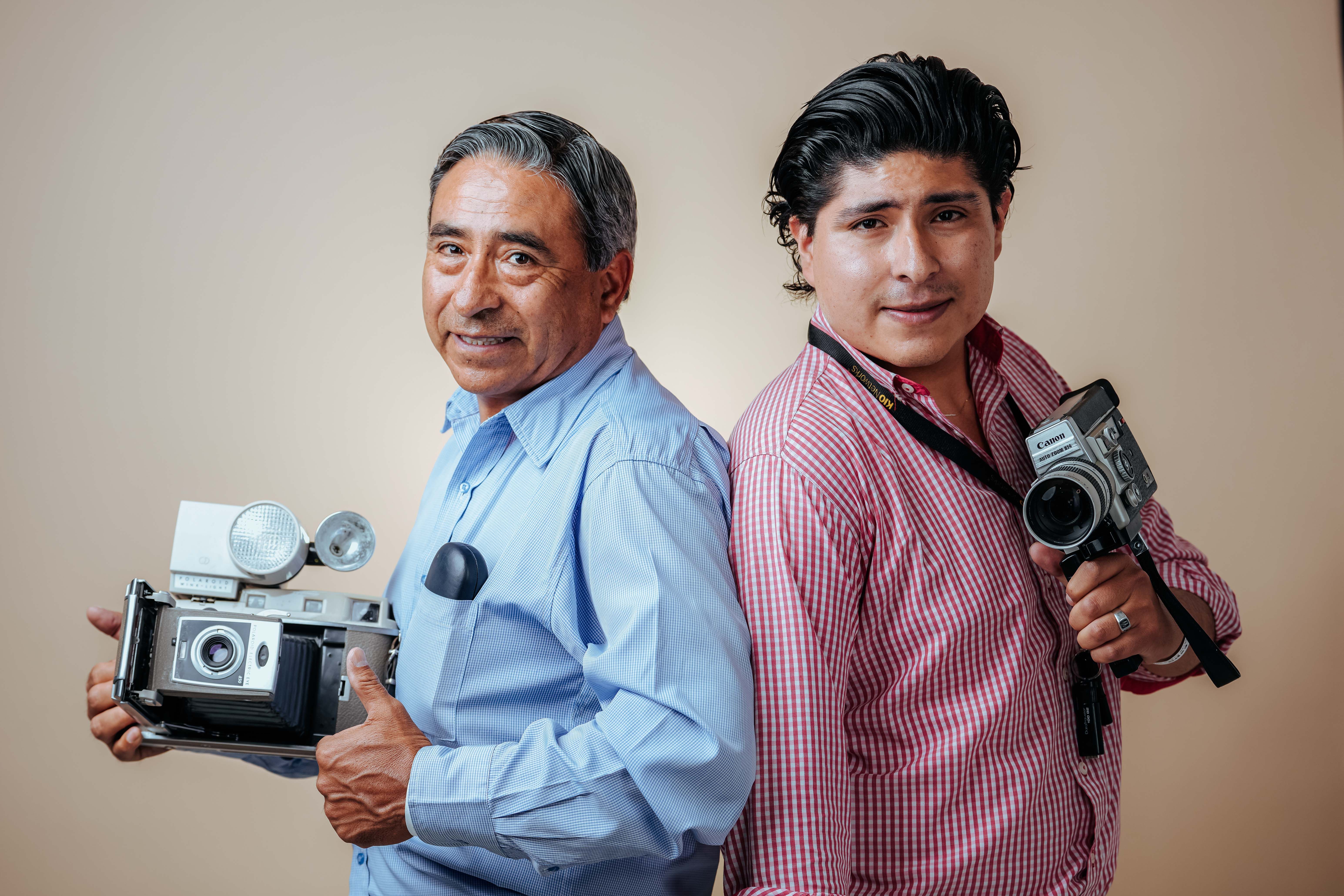 Photo of Two Men Posing with Vintage Cameras · Free Stock Photo