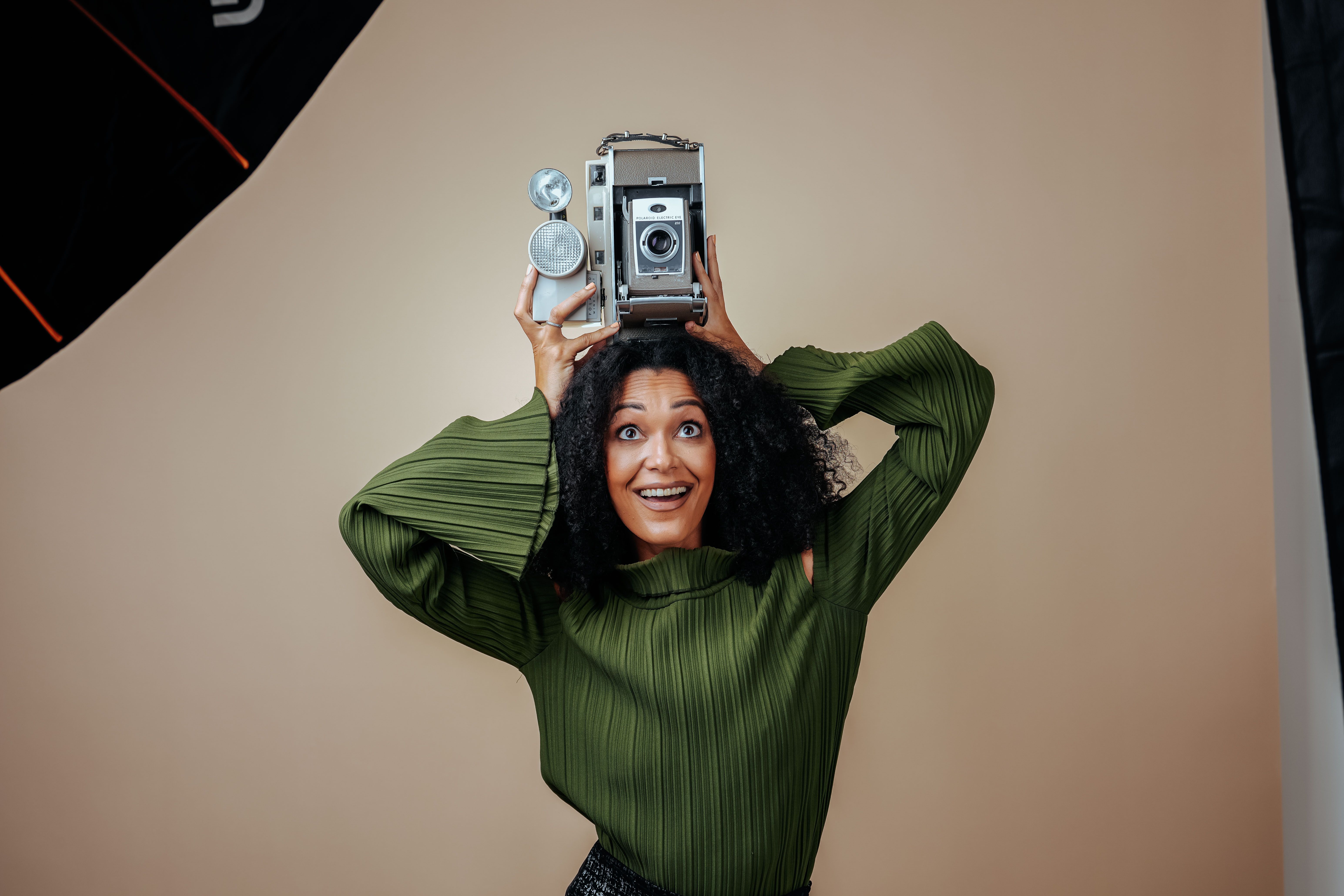 Photo of a Smiling Woman Holding a Vintage Camera Above Her Head · Free ...