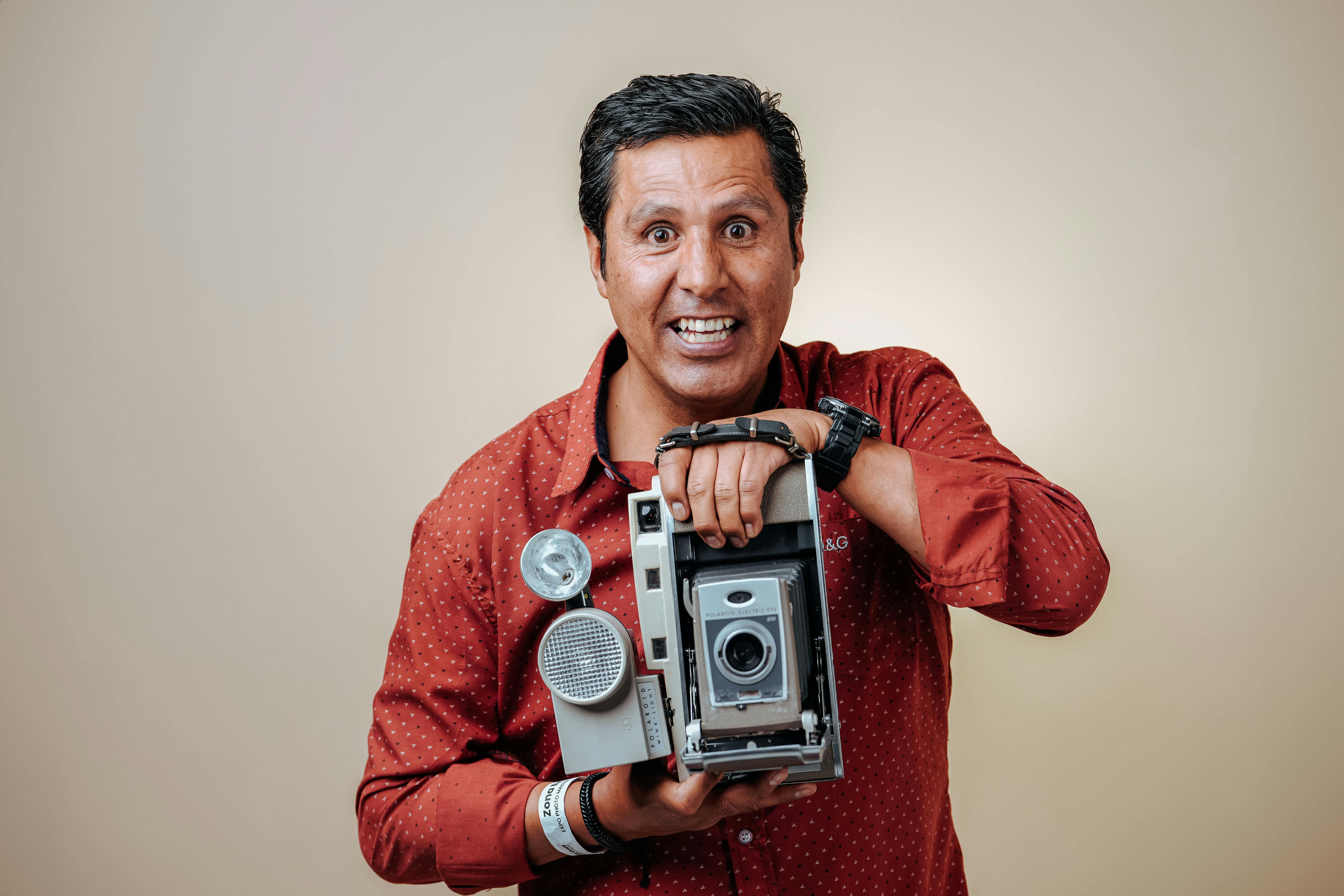 Photo of a Smiling Man with a Vintage Camera · Free Stock Photo