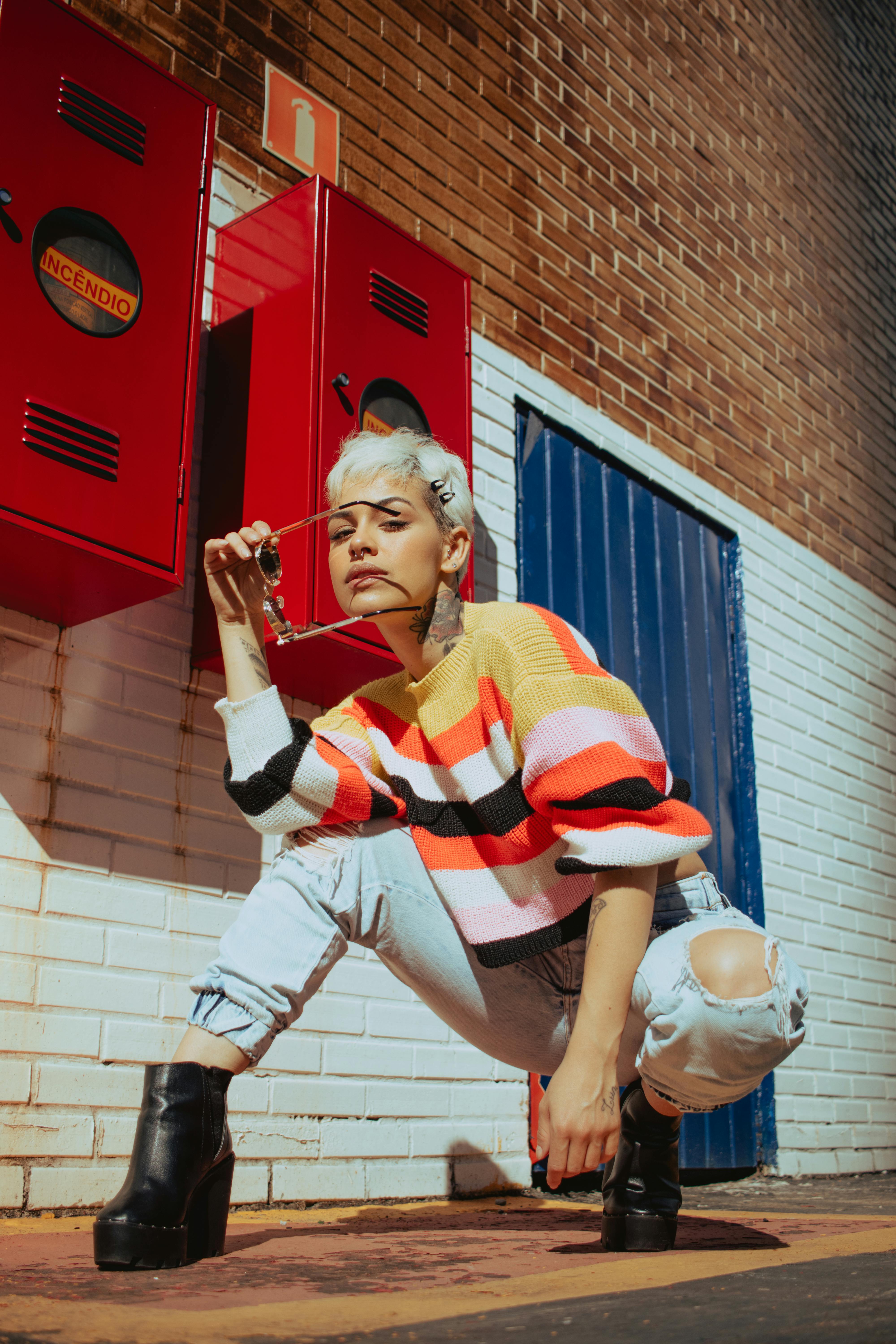 Woman Crouching near Wall · Free Stock Photo