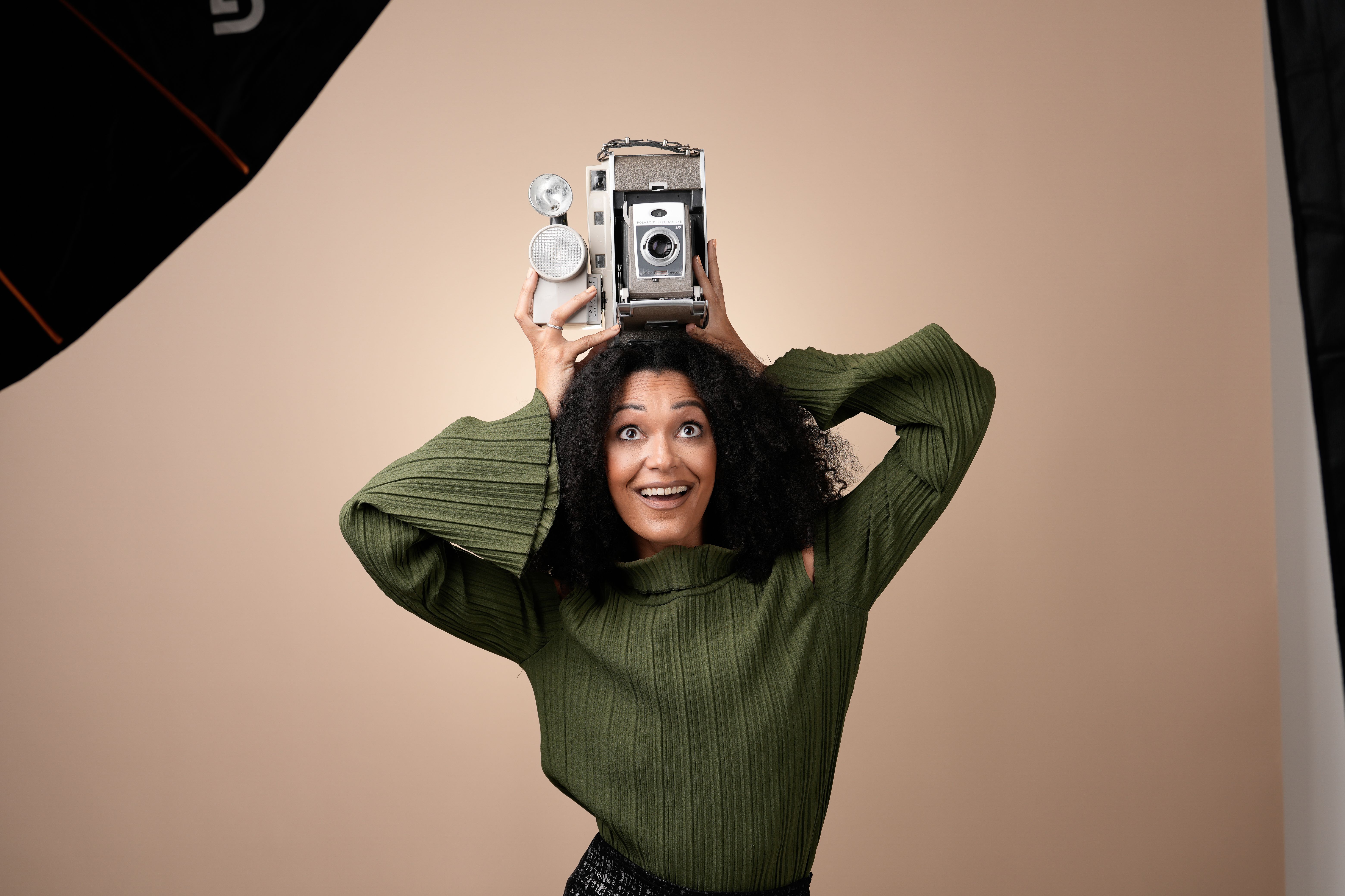 Smiling Woman Holding Vintage Camera over Hair · Free Stock Photo