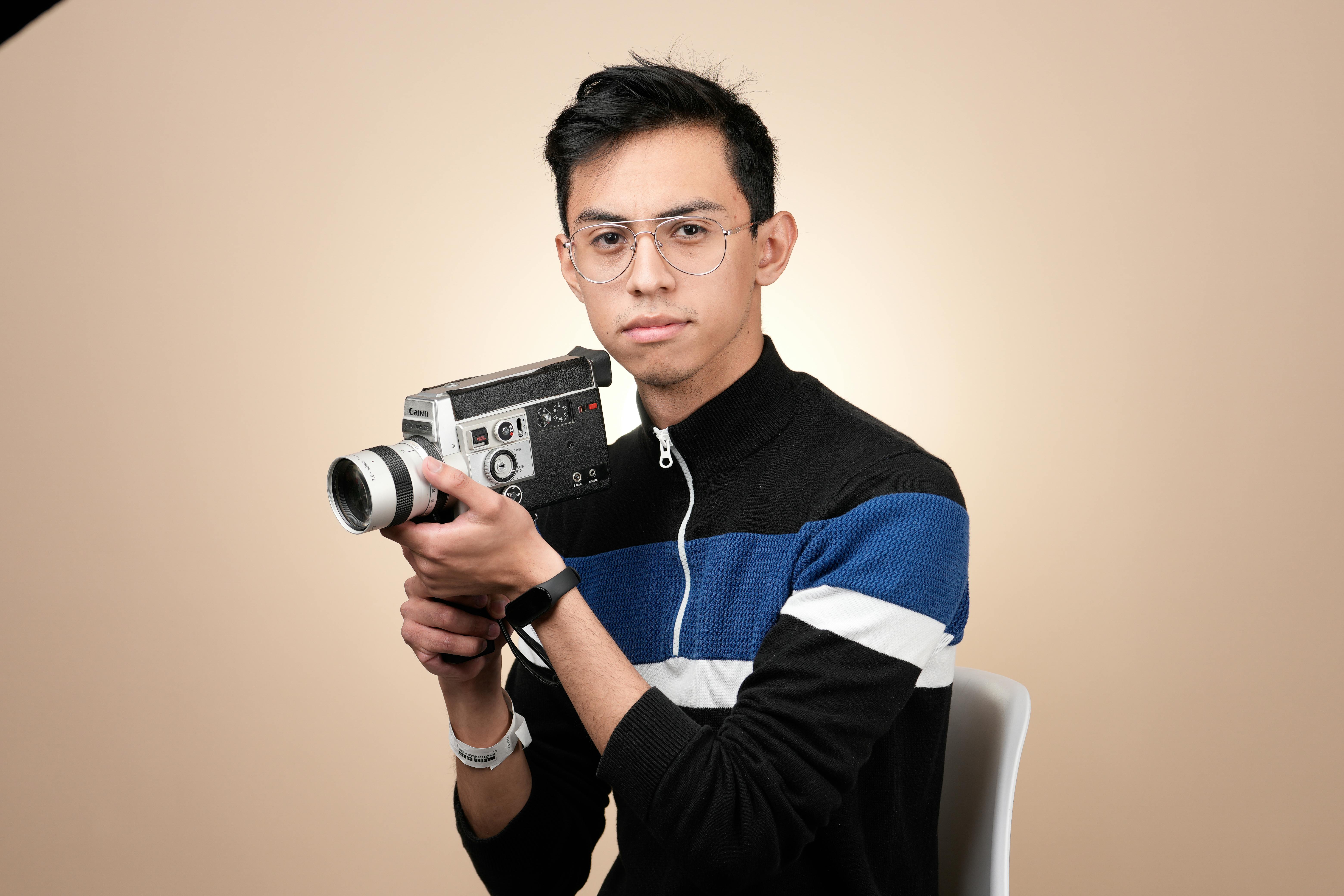 Photo of a Man Holding a Nikon Camera · Free Stock Photo