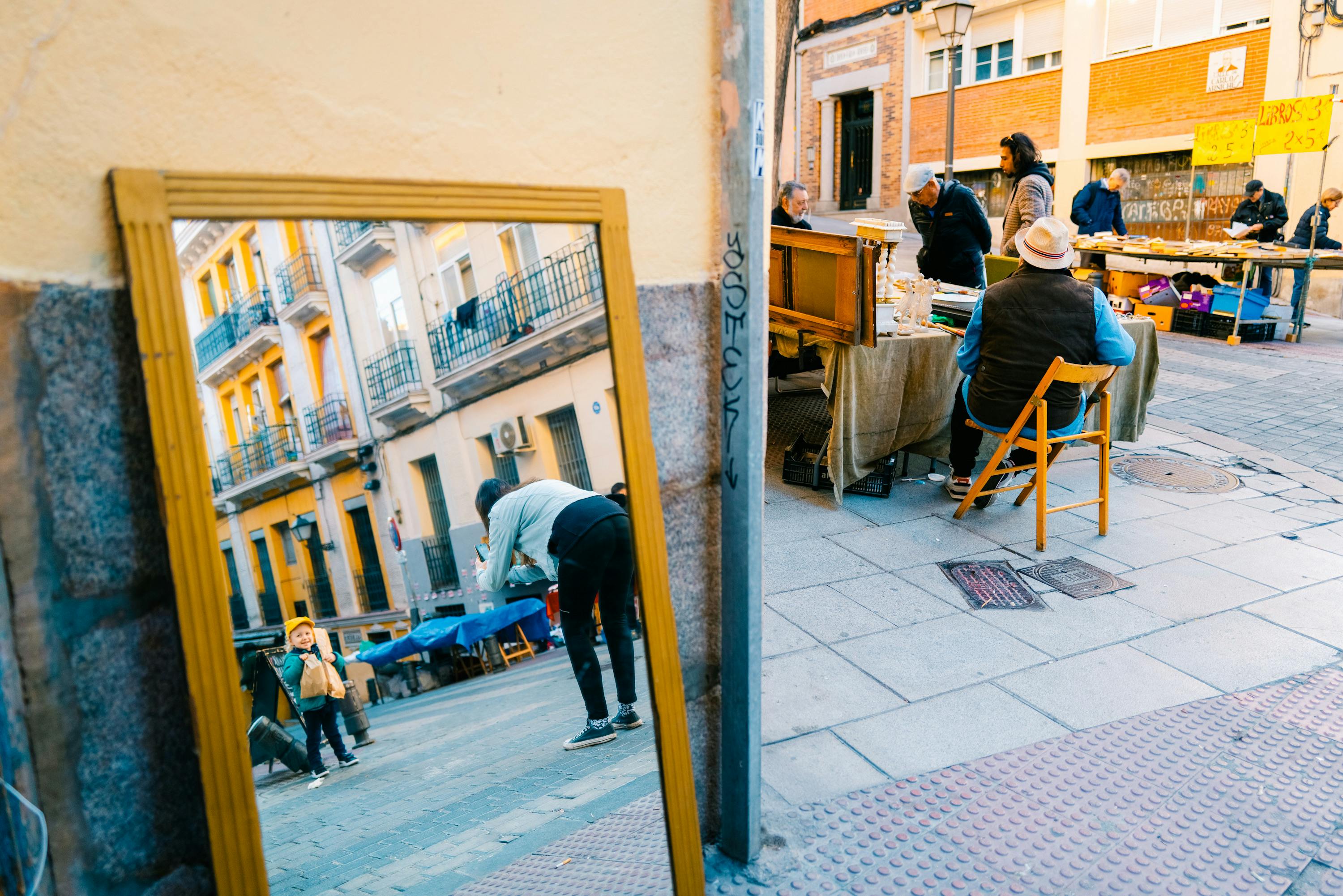 Woman Taking a Photo of Child Reflecting in Mirror on Urban Street ...