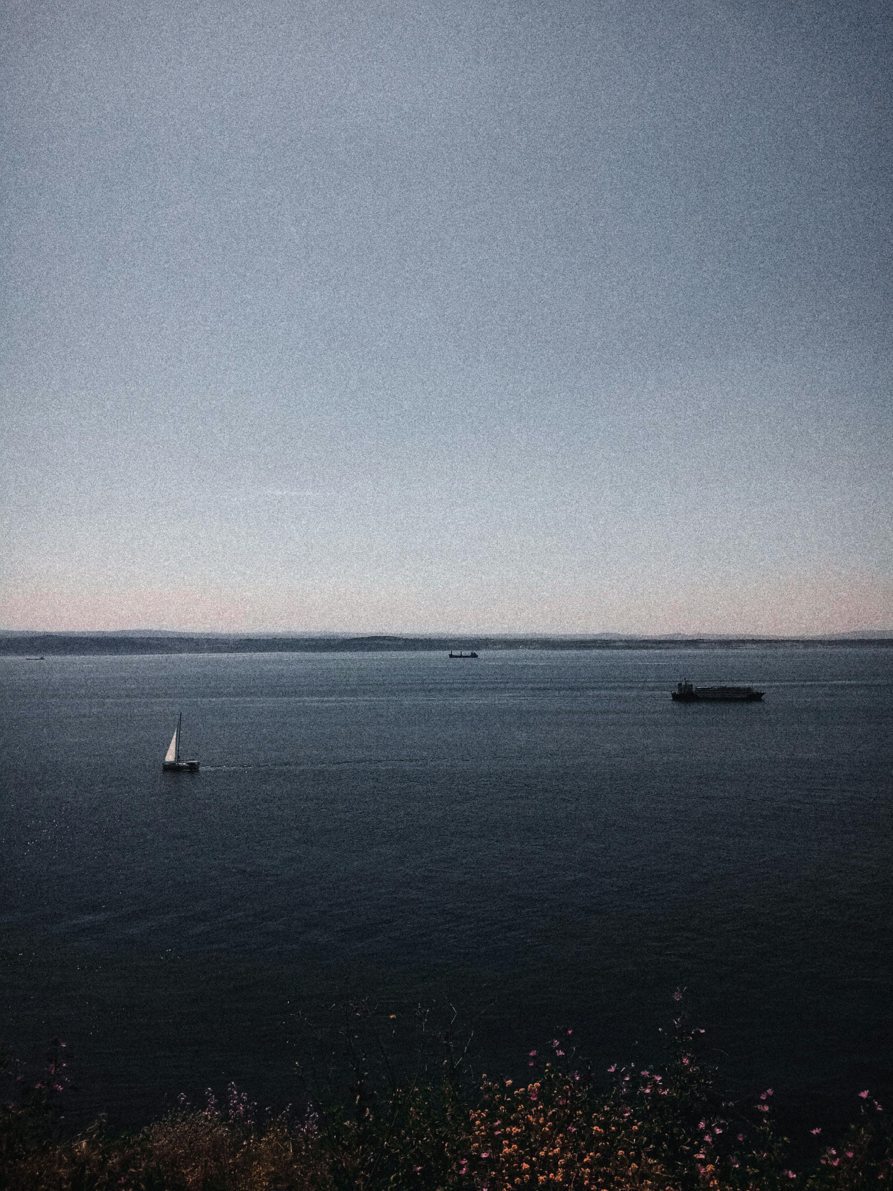 A boat sailing in the ocean near a body of water · Free Stock Photo