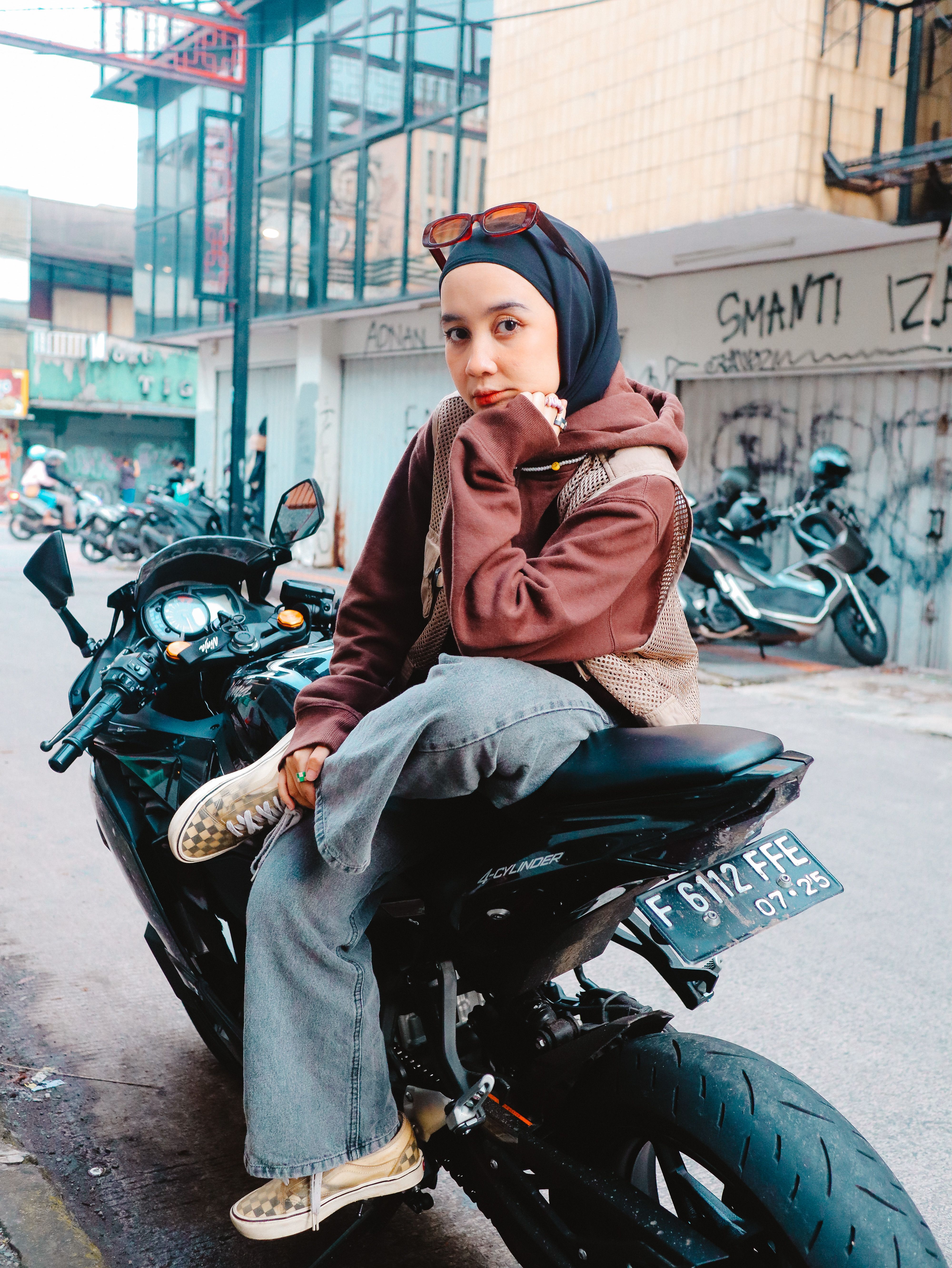 Girl in Hijab Sitting on Motorcycle on Street · Free Stock Photo