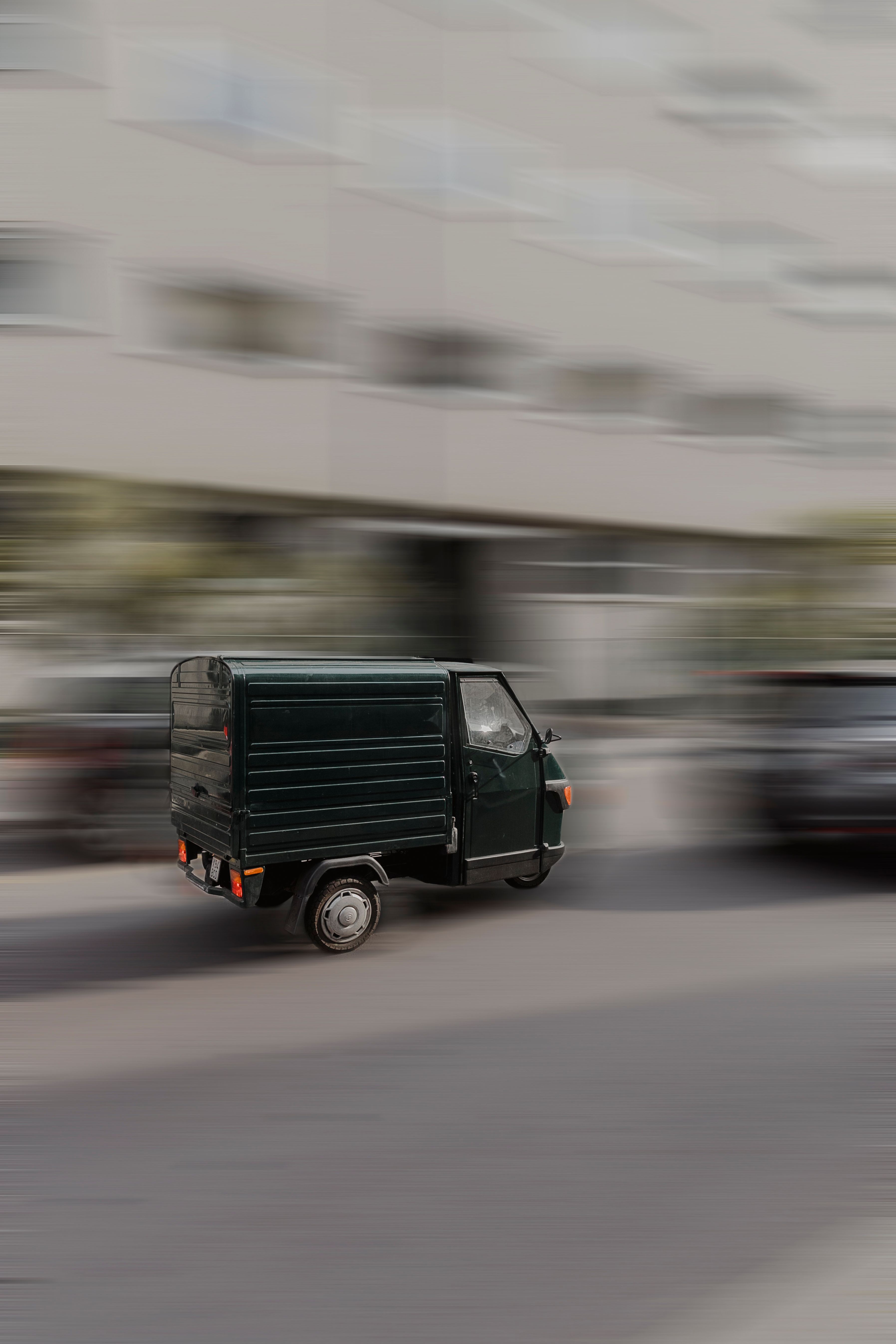 Piaggio Ape Car Driving down City Street · Free Stock Photo