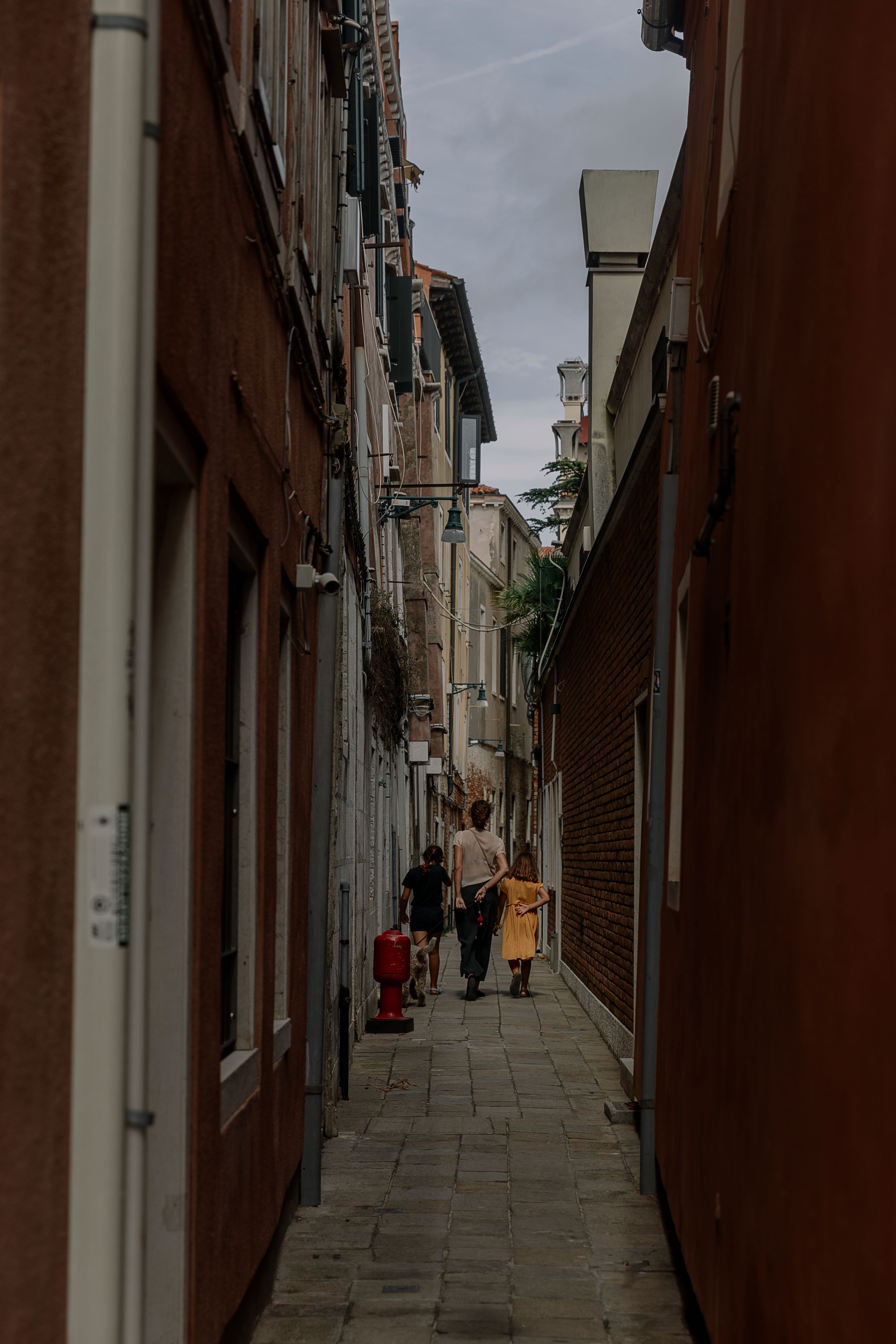 A Man Standing in the Narrow Street Sidewalk · Free Stock Photo