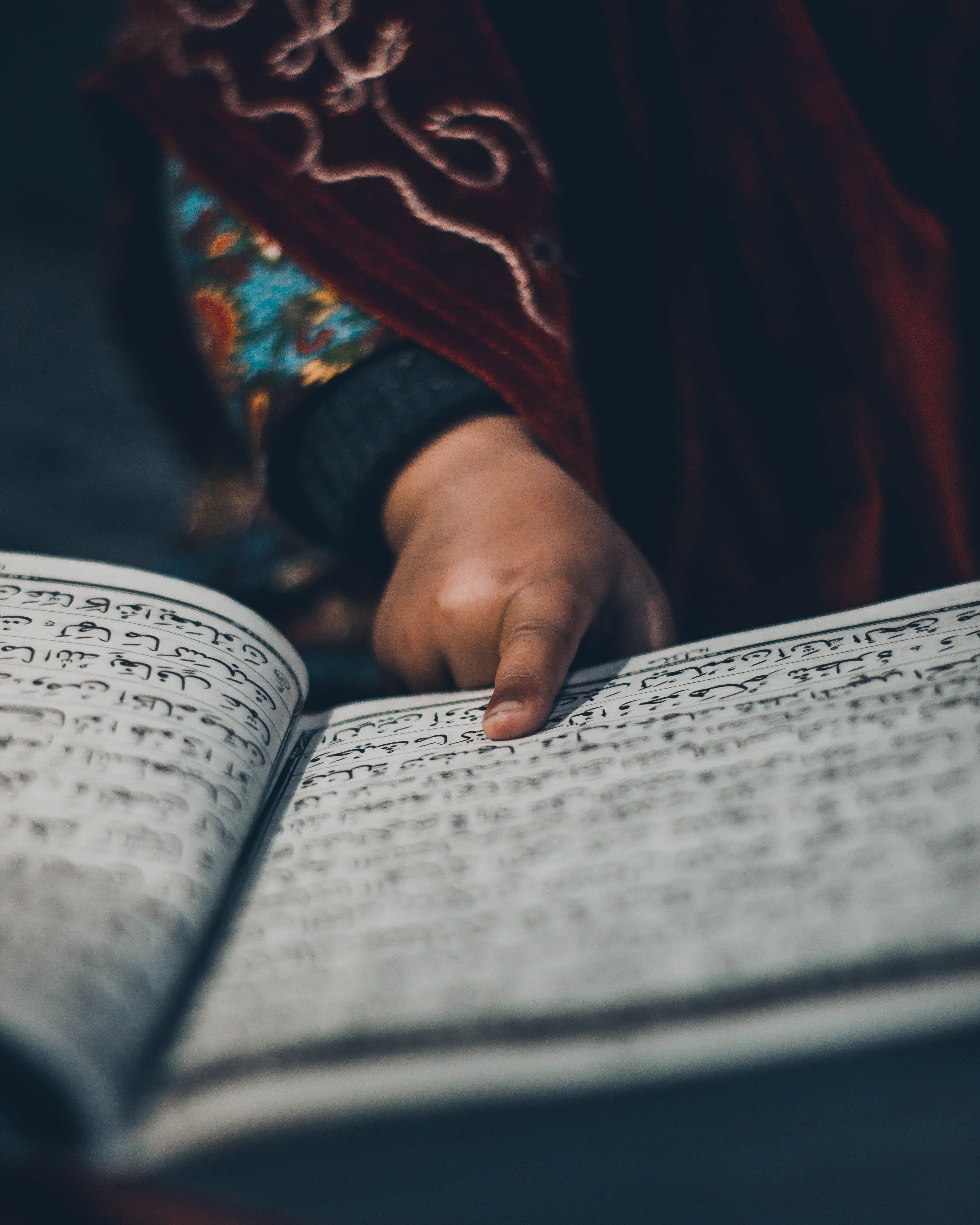 Finger on Book Page in Arabic · Free Stock Photo