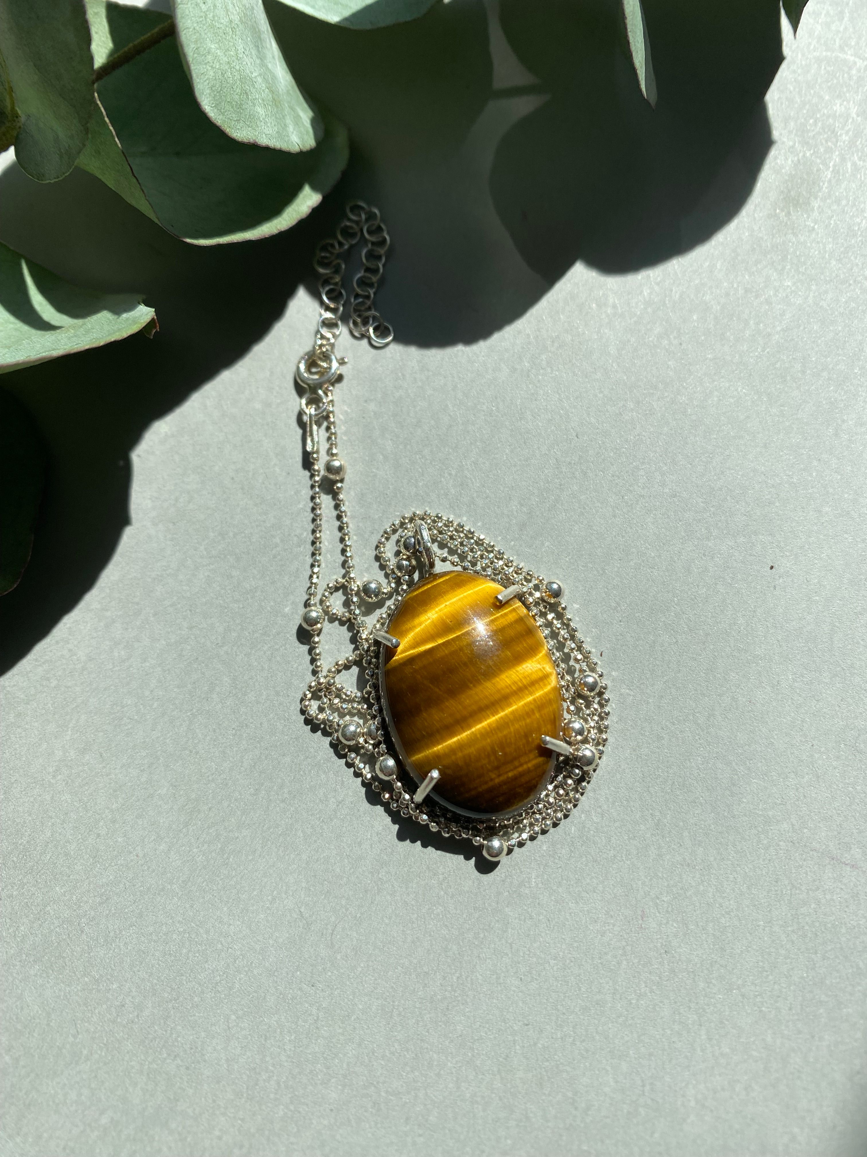 Close-up of a Necklace with a Yellow Stone Pendant · Free Stock Photo