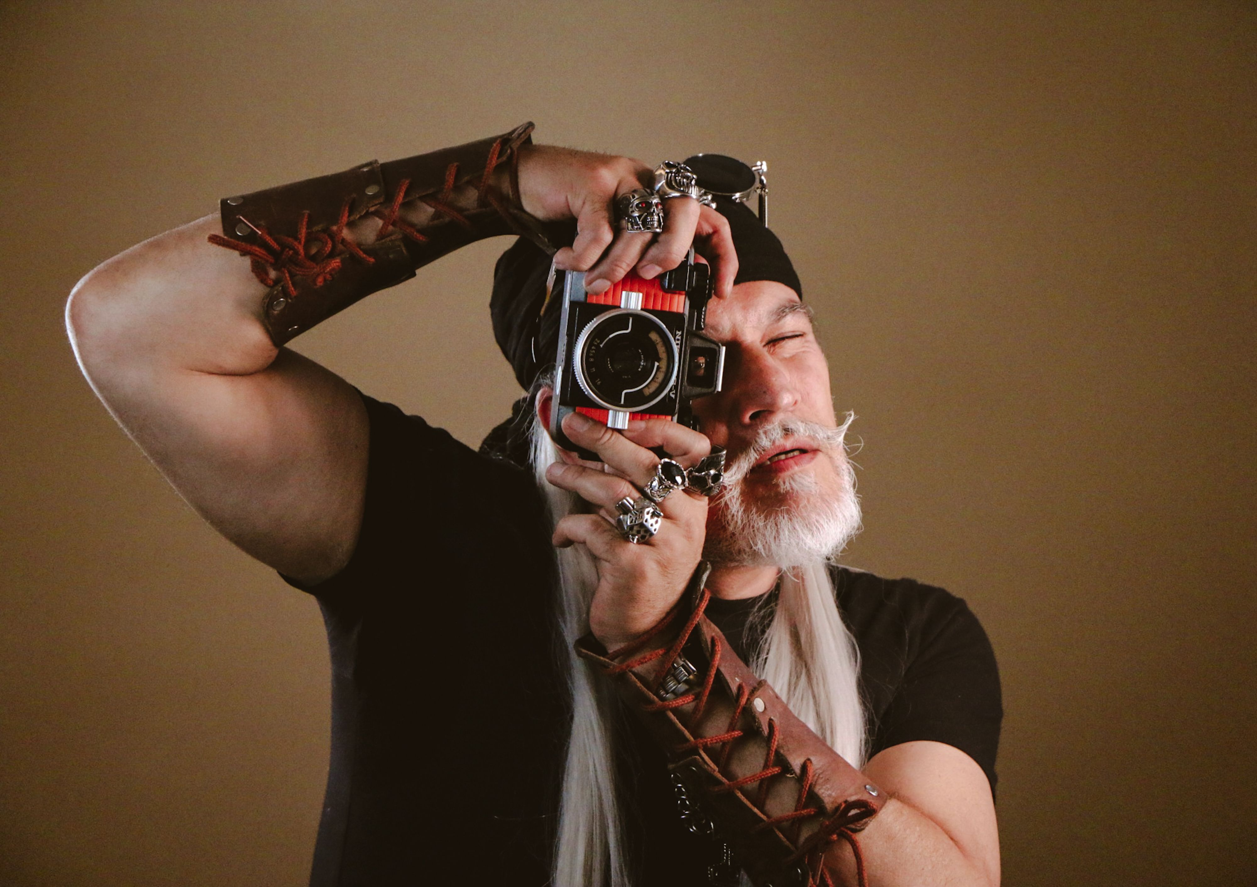 Man with Long Hair Holding Camera and Taking Pictures · Free Stock Photo