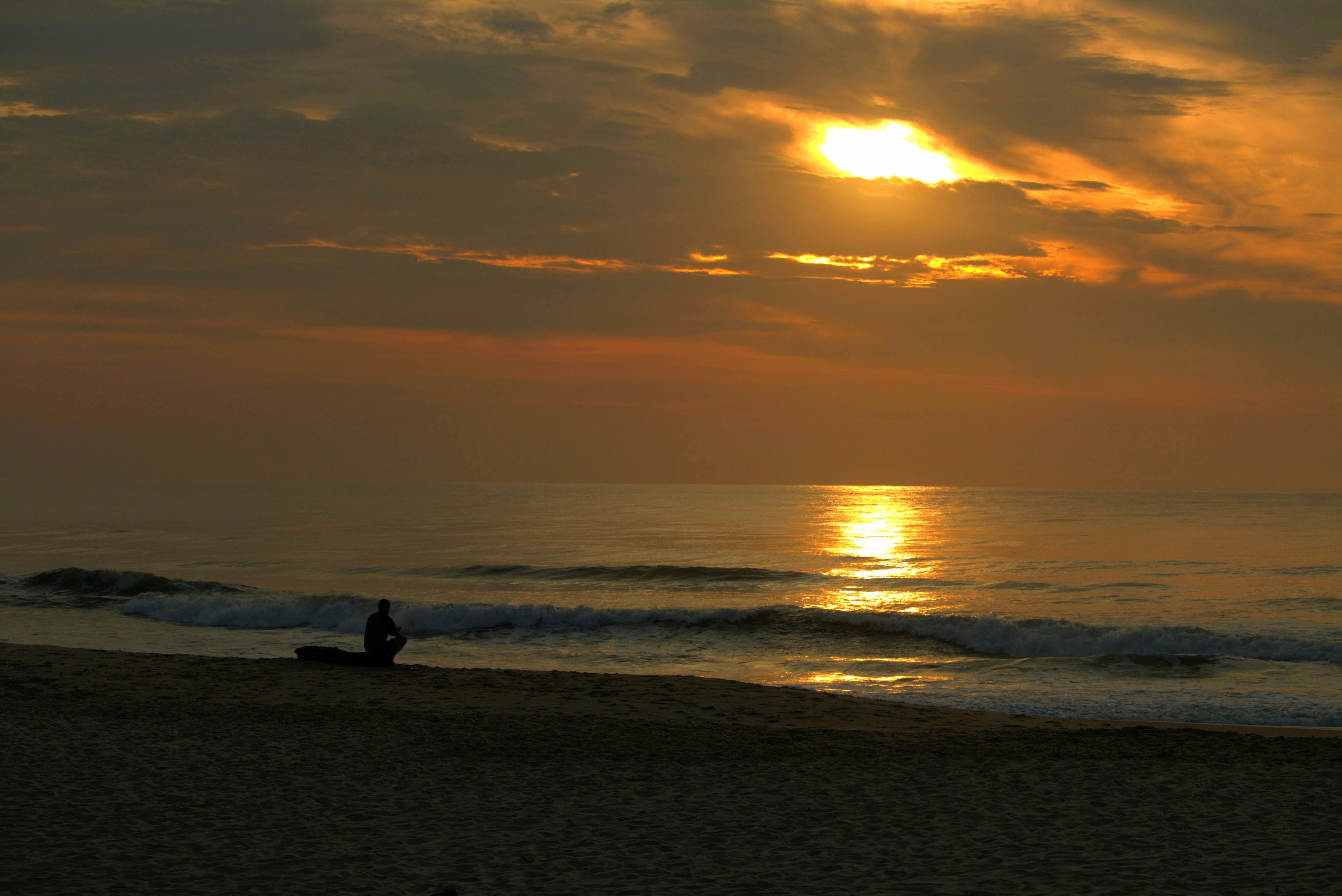 A Person Sitting Alone on the Beach at Sunset · Free Stock Photo