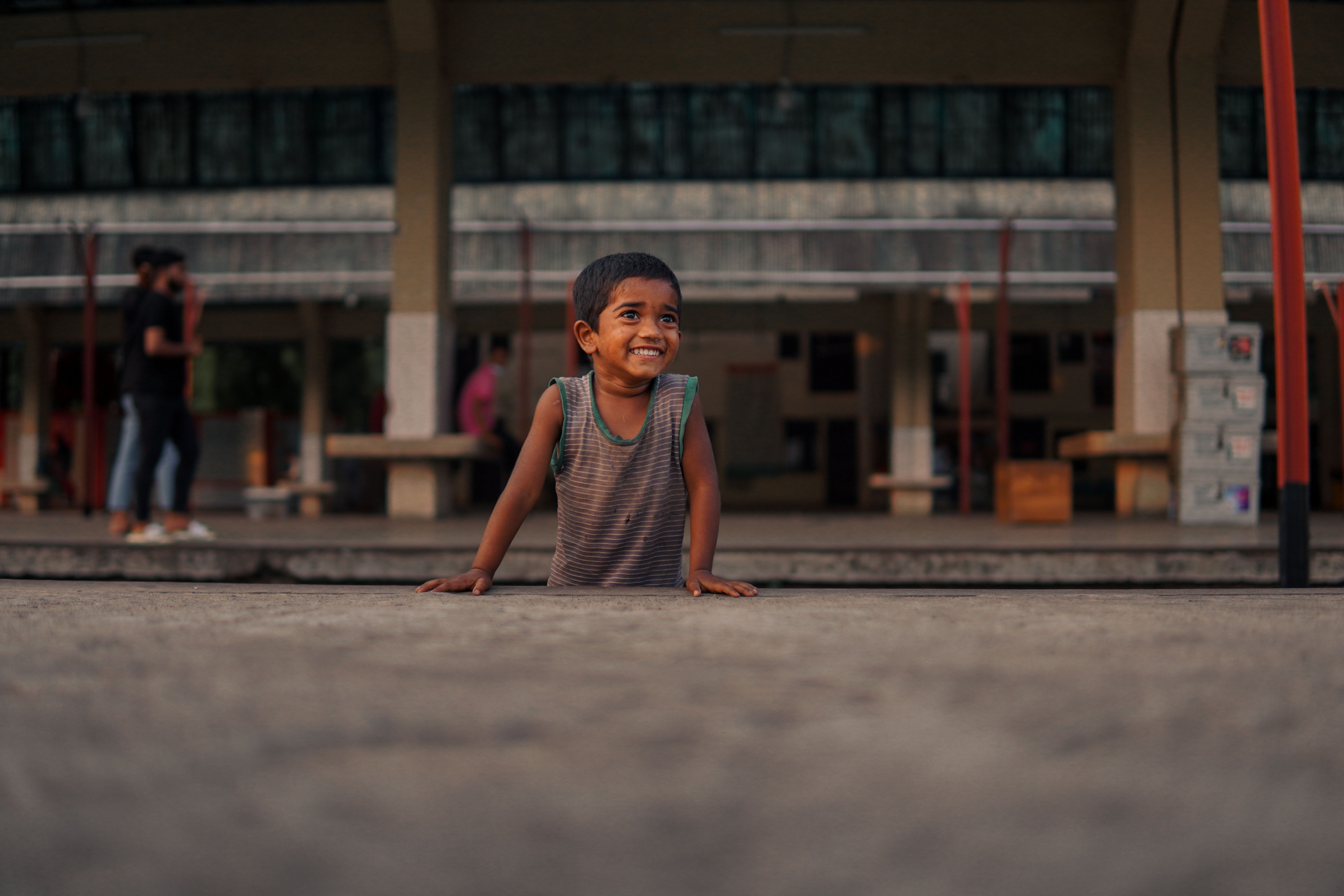 Smiling Boy Standing behind Wall · Free Stock Photo
