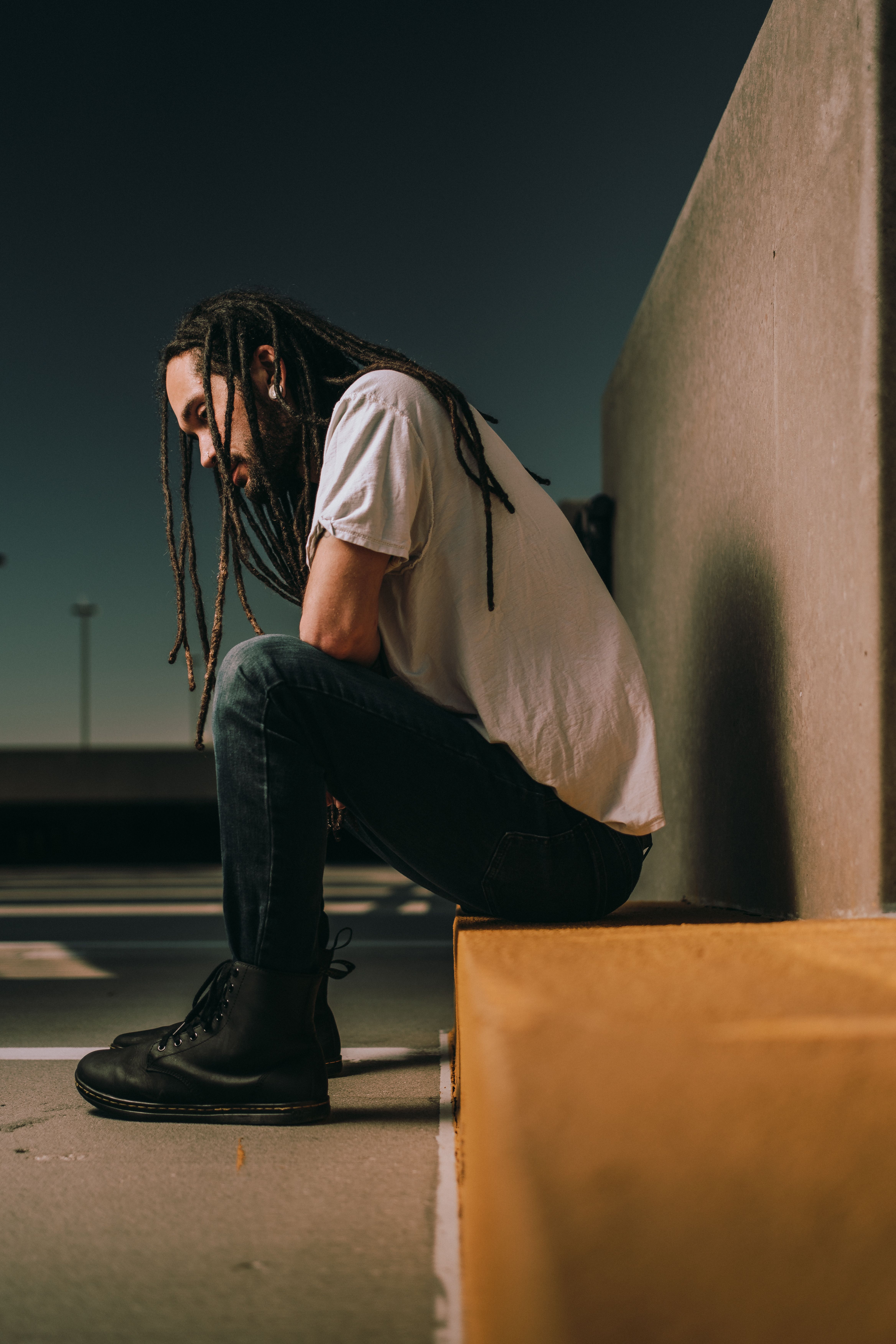 Side View of a Man with Dreadlocks Sitting on a Bench · Free Stock Photo