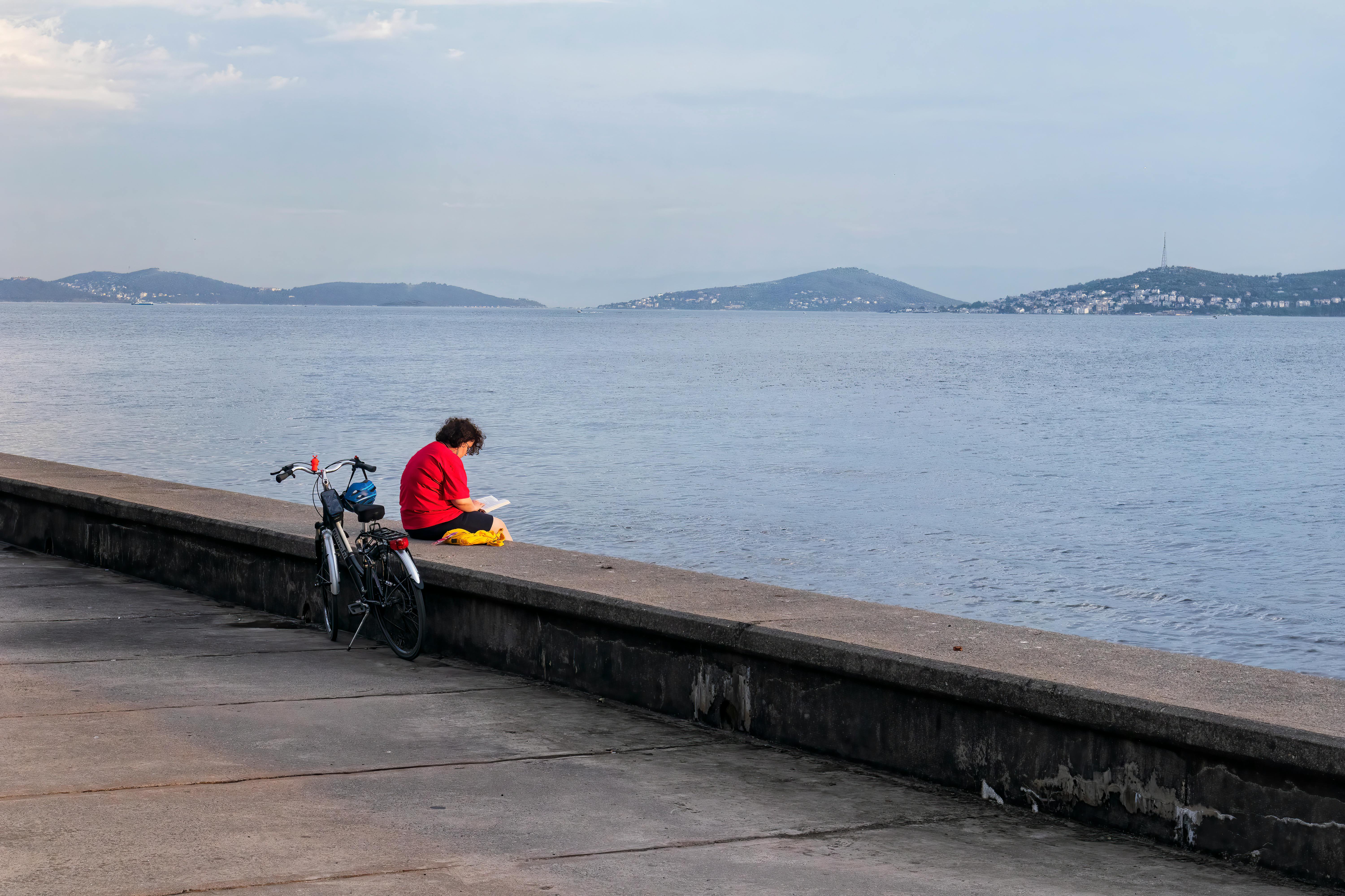 Woman Reading a Book Sitting on the Edge of the Pier · Free Stock Photo