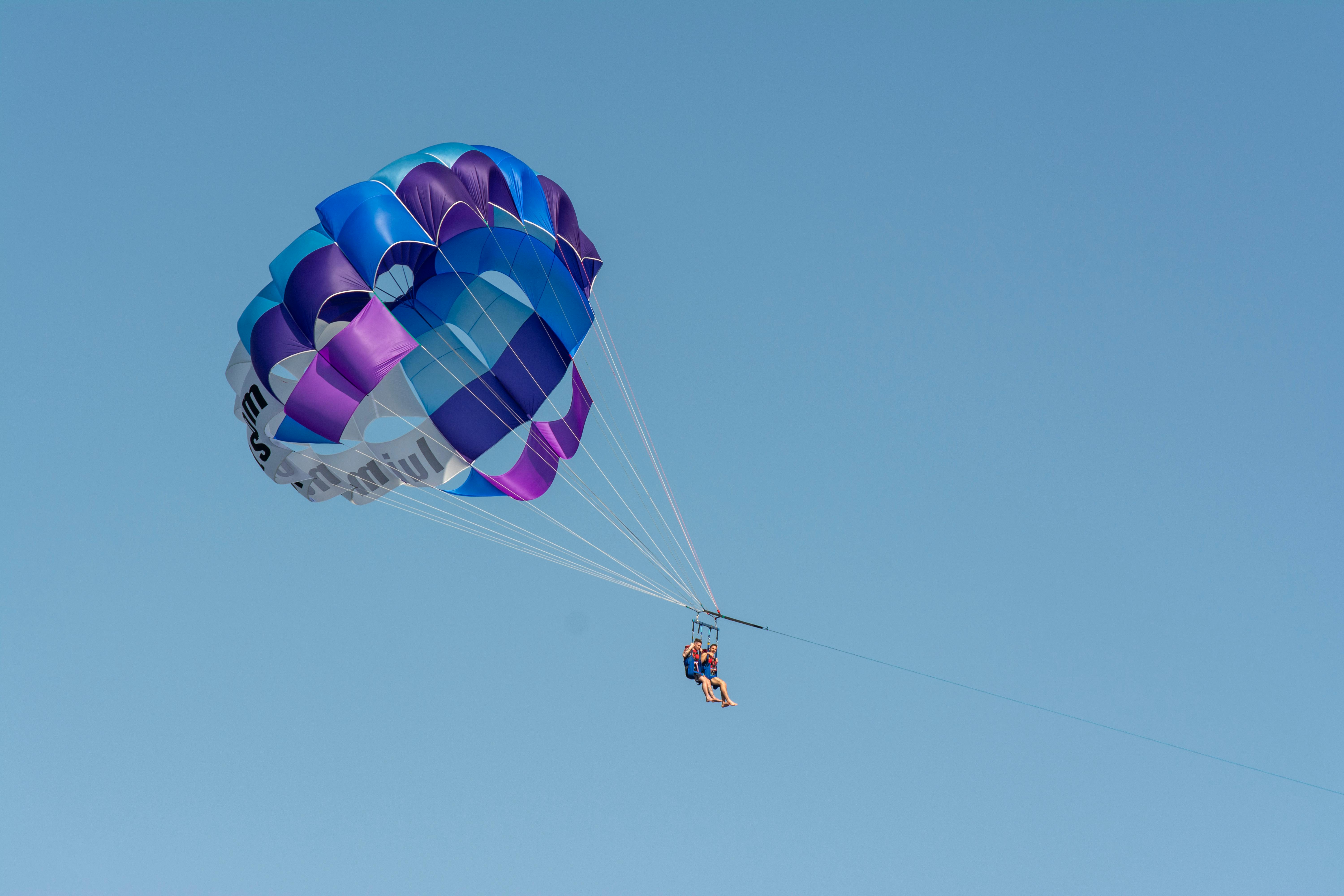 Person Flying on Parachute in Blue Sky · Free Stock Photo