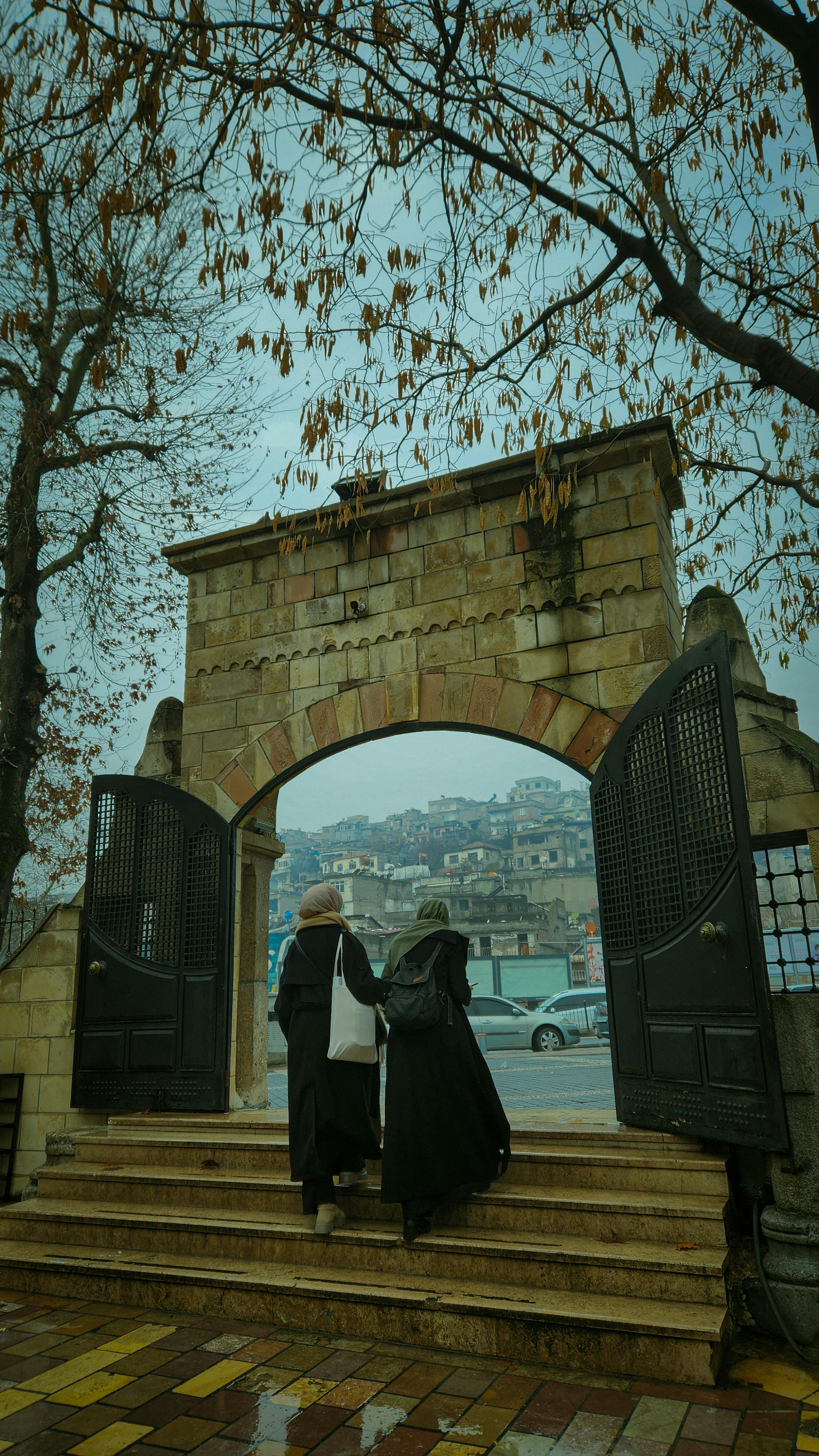 People Walking on Pavement under Large Entrance Gate · Free Stock Photo