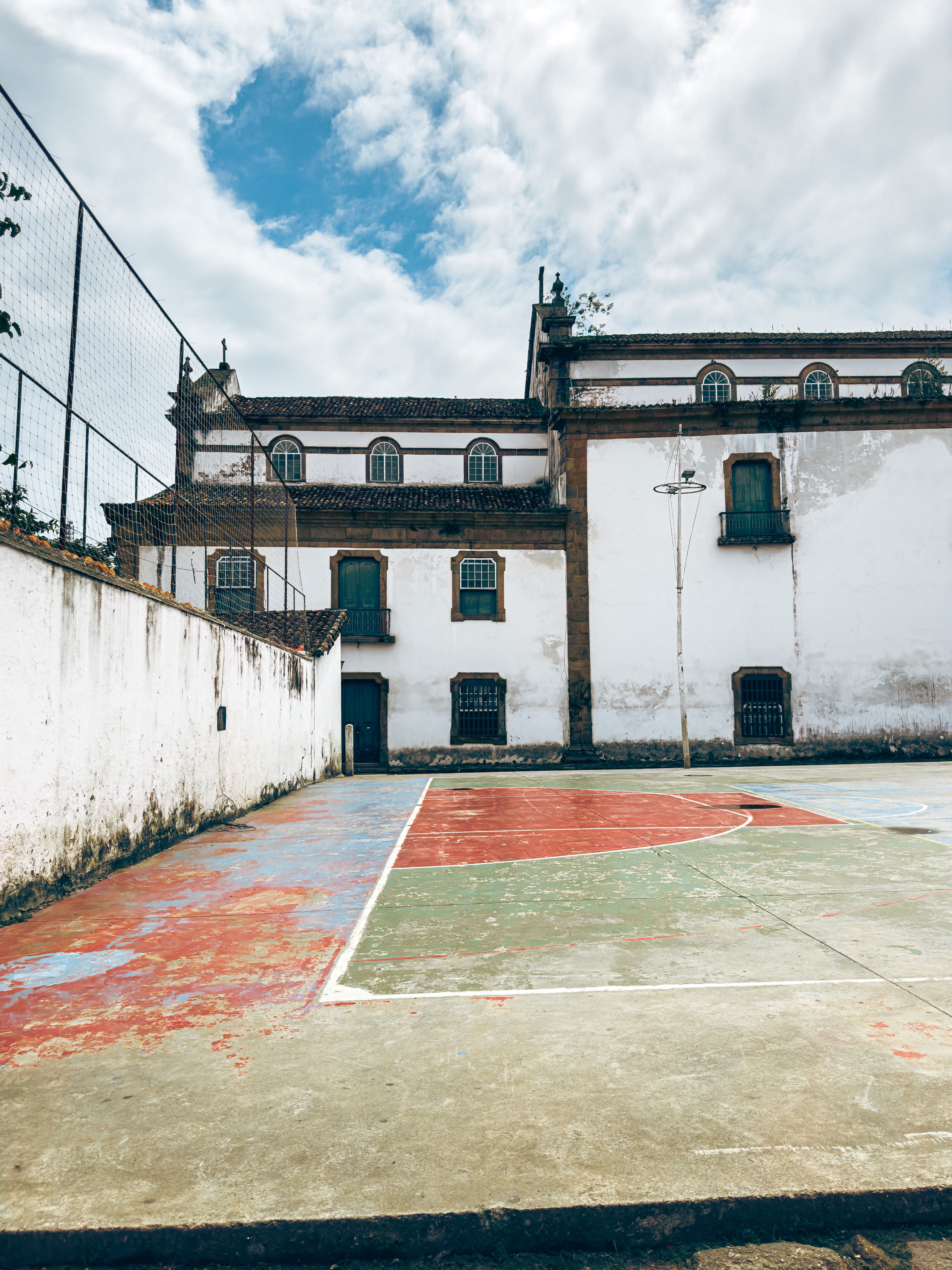 An Outdoor Basketball Court in front of a Traditional Building in City ...