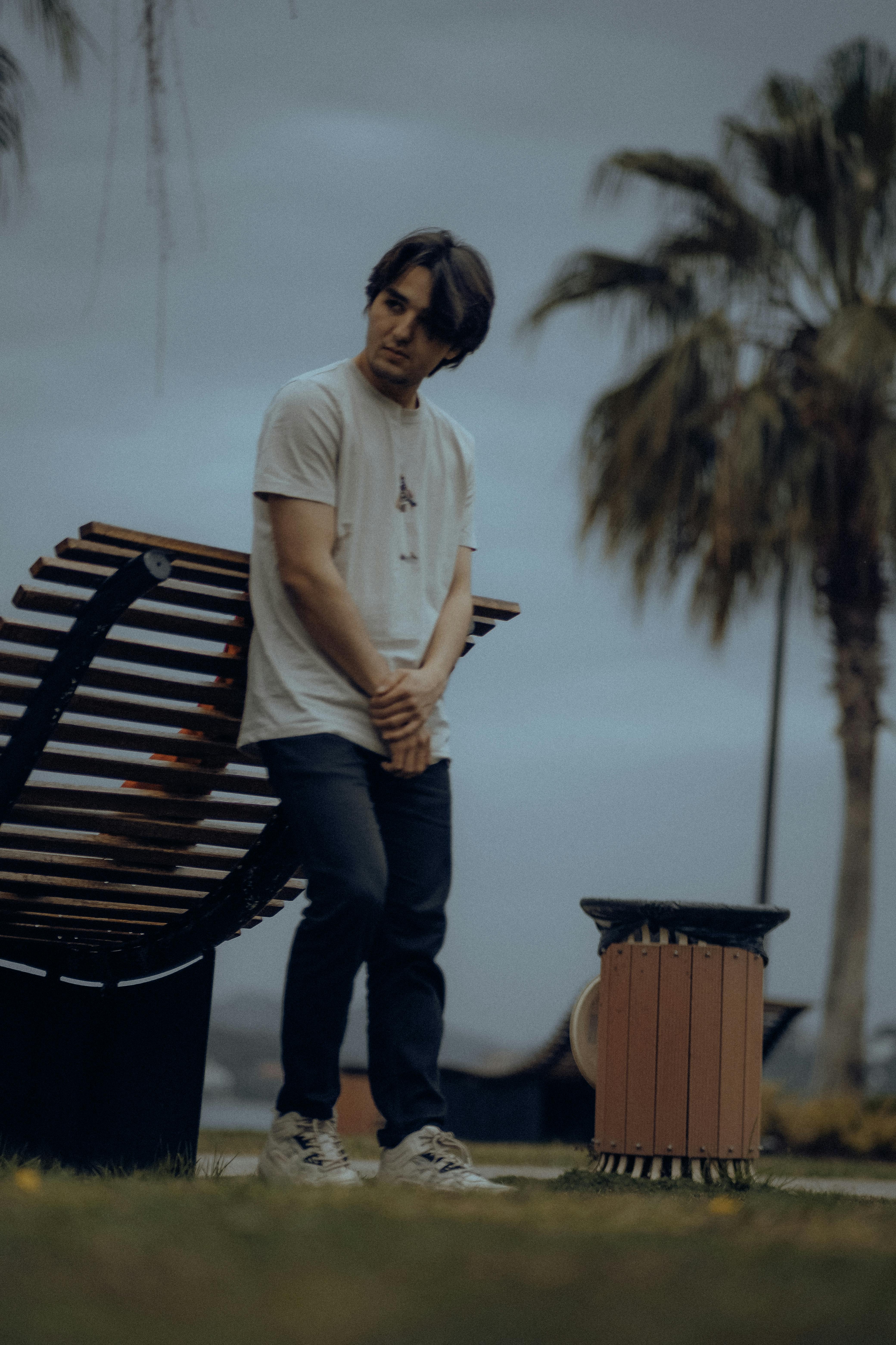 Man Leaning on Modern Wooden Bench · Free Stock Photo