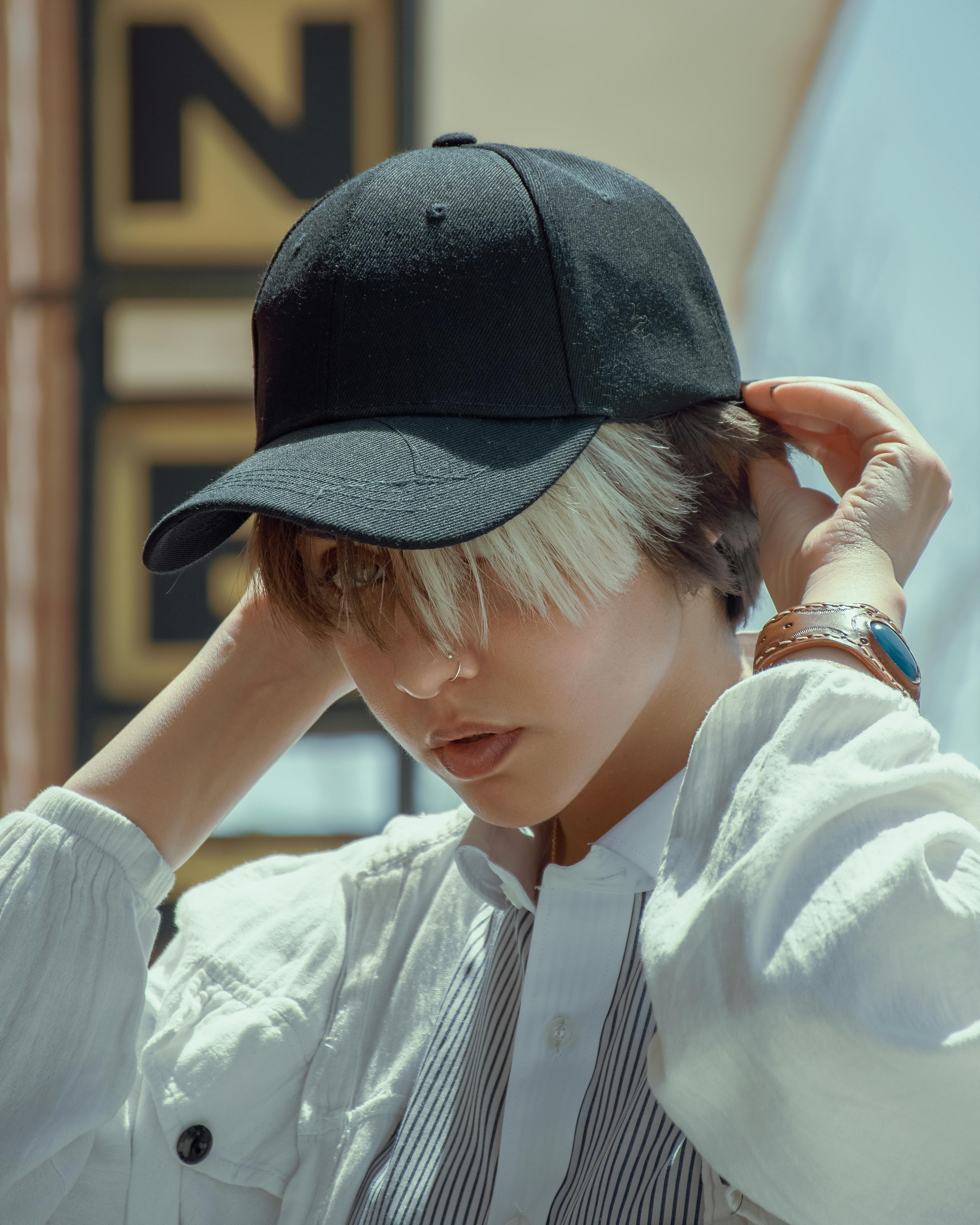 Woman Fixing Hair under Baseball Cap · Free Stock Photo