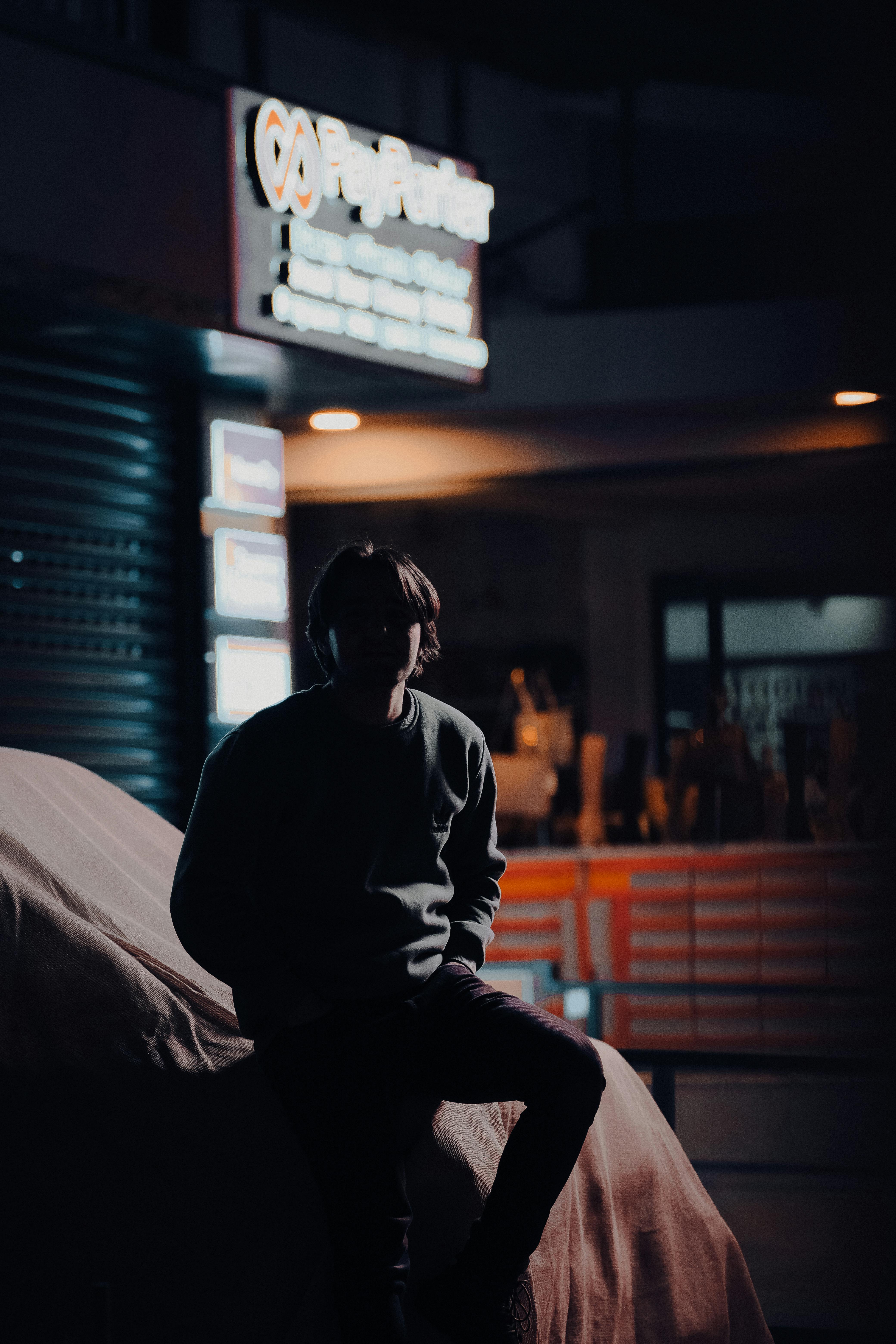 Person Sitting in Shadow in Building Entrance · Free Stock Photo