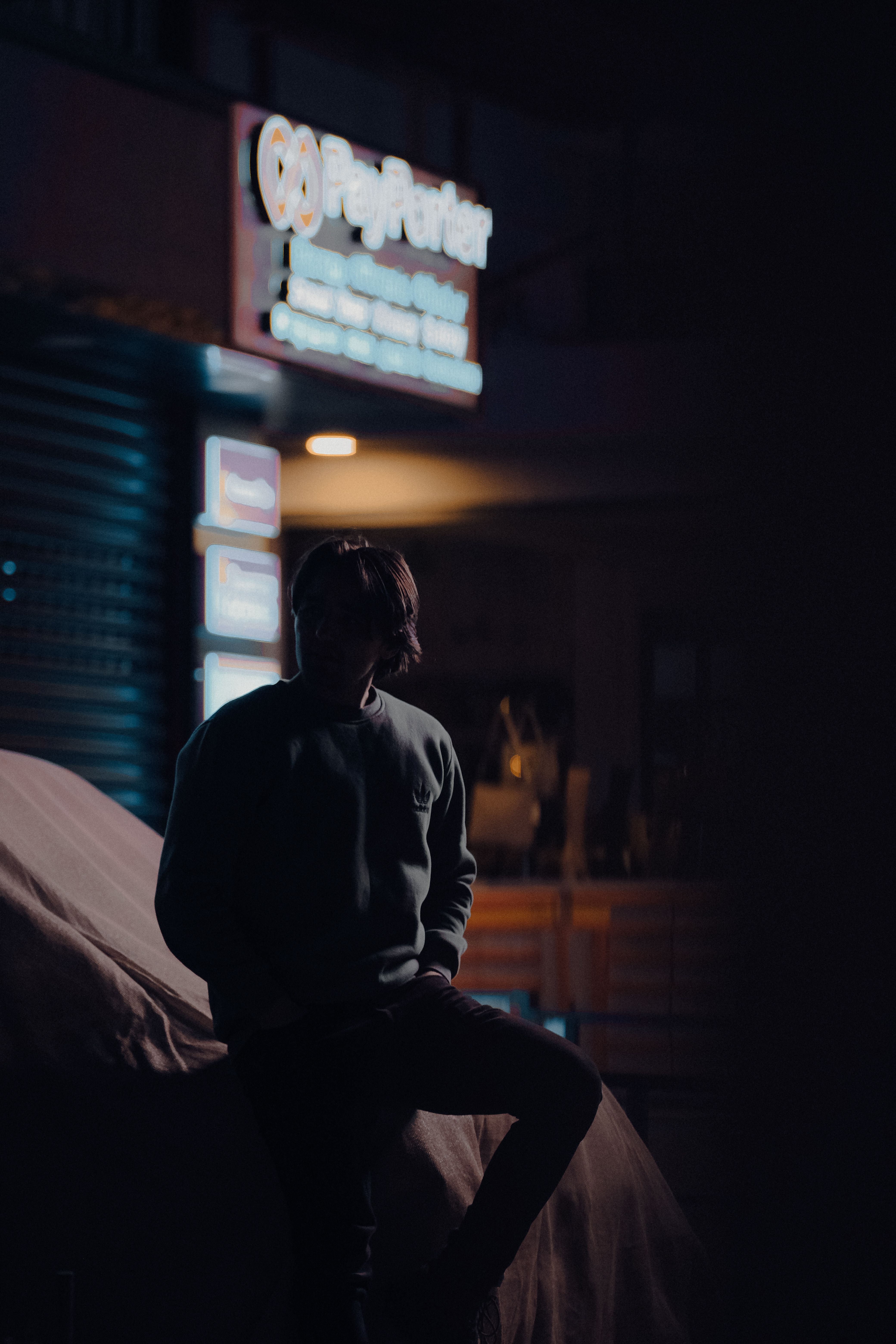 Man Sitting and Posing in Town at Night · Free Stock Photo